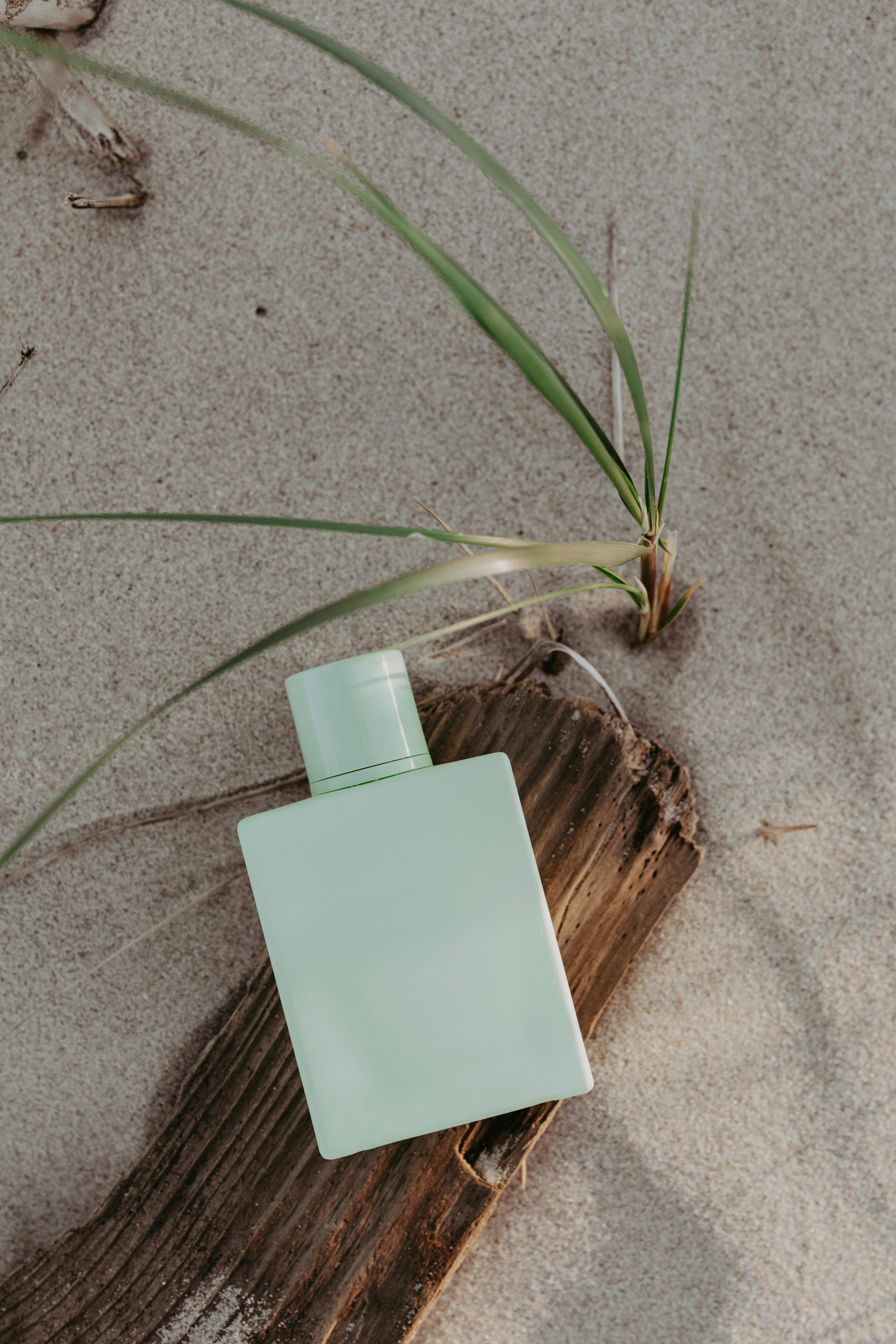 Square Glass Perfume Bottle on White Sand · Free Stock Photo