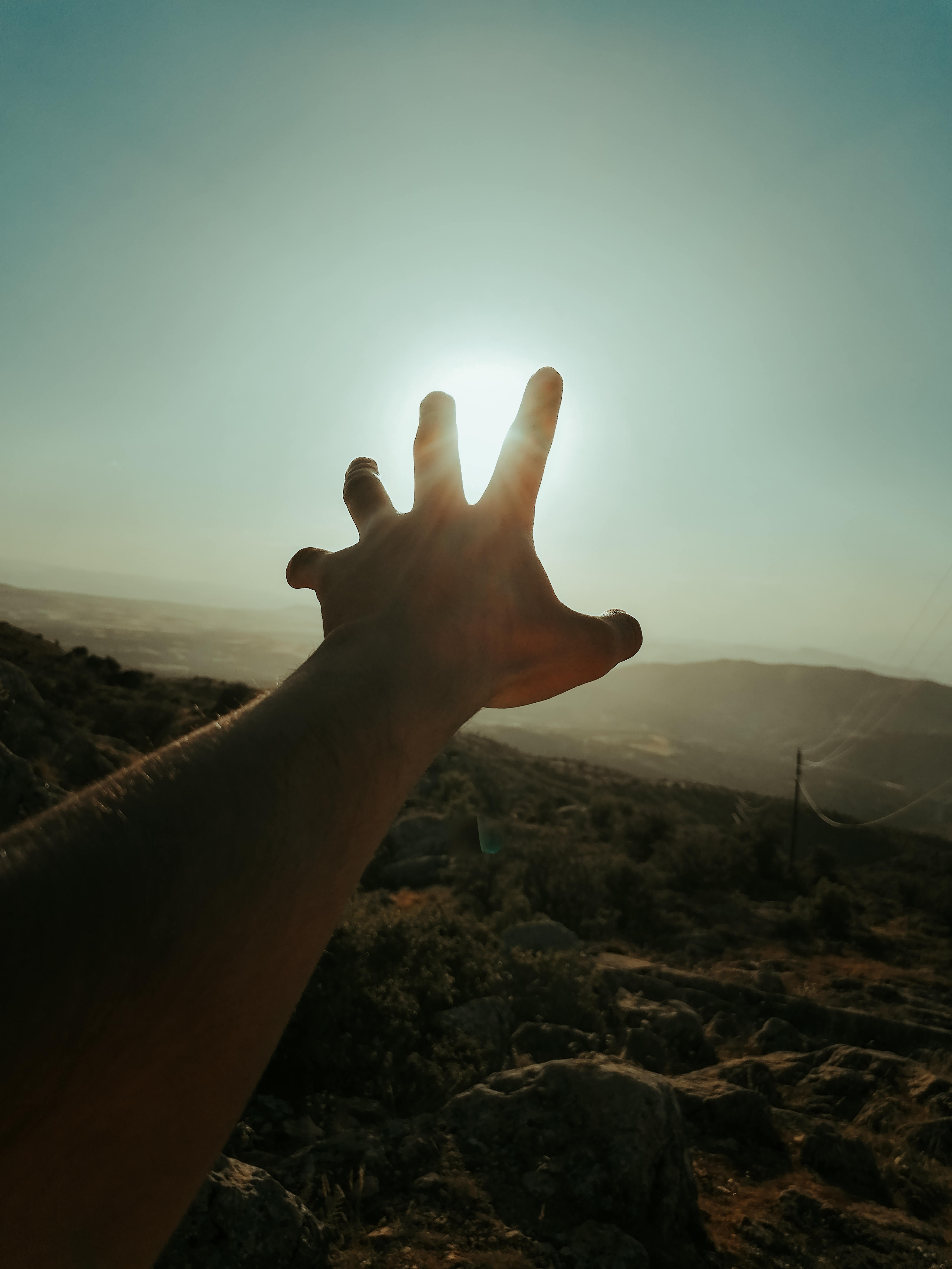 A Person Covering Sunlight with a Hand · Free Stock Photo