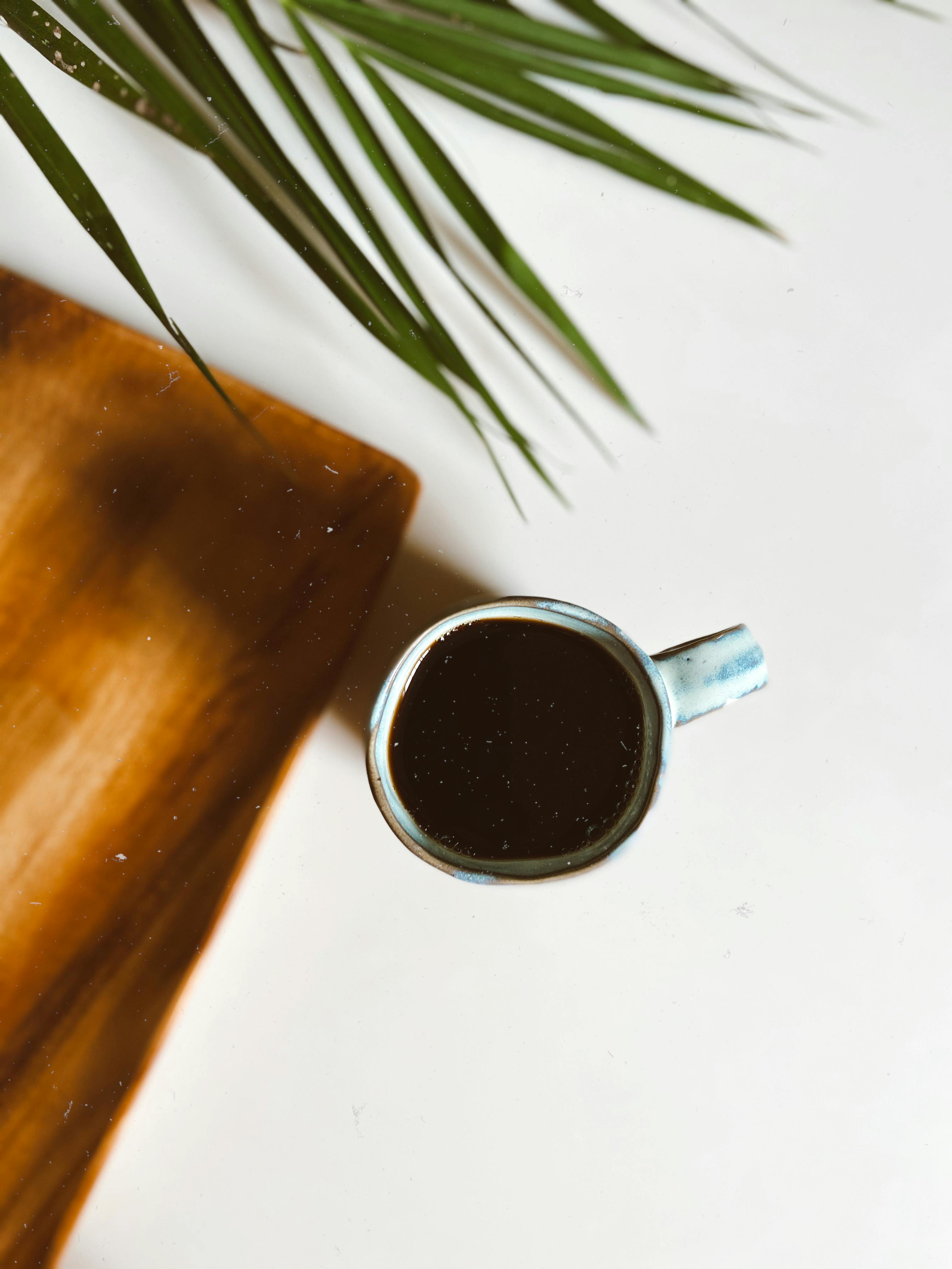 Earring Lying on a Table Next to Coffee · Free Stock Photo