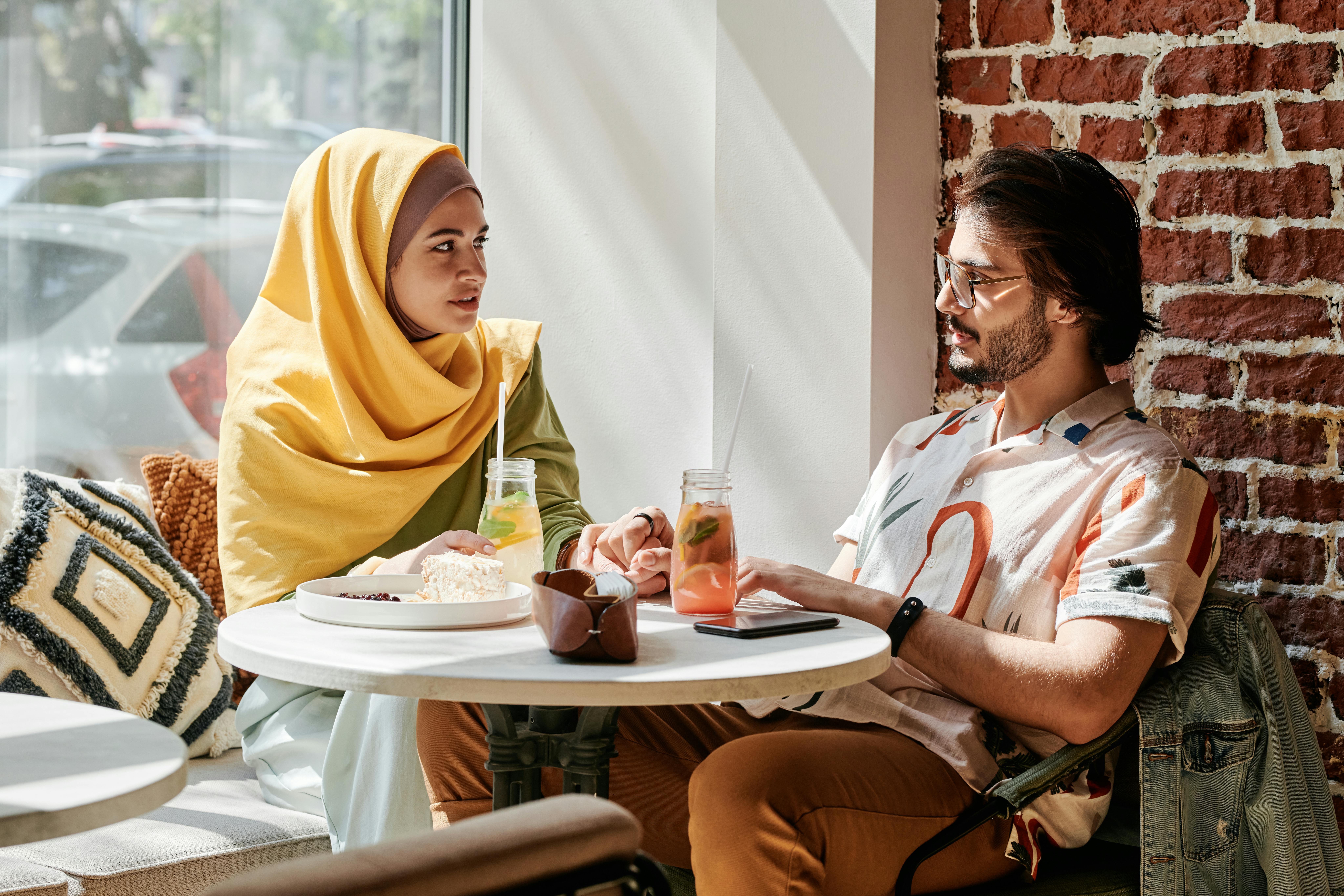 A Couple Holding Each Others Hand while Eating Inside a Café · Free ...