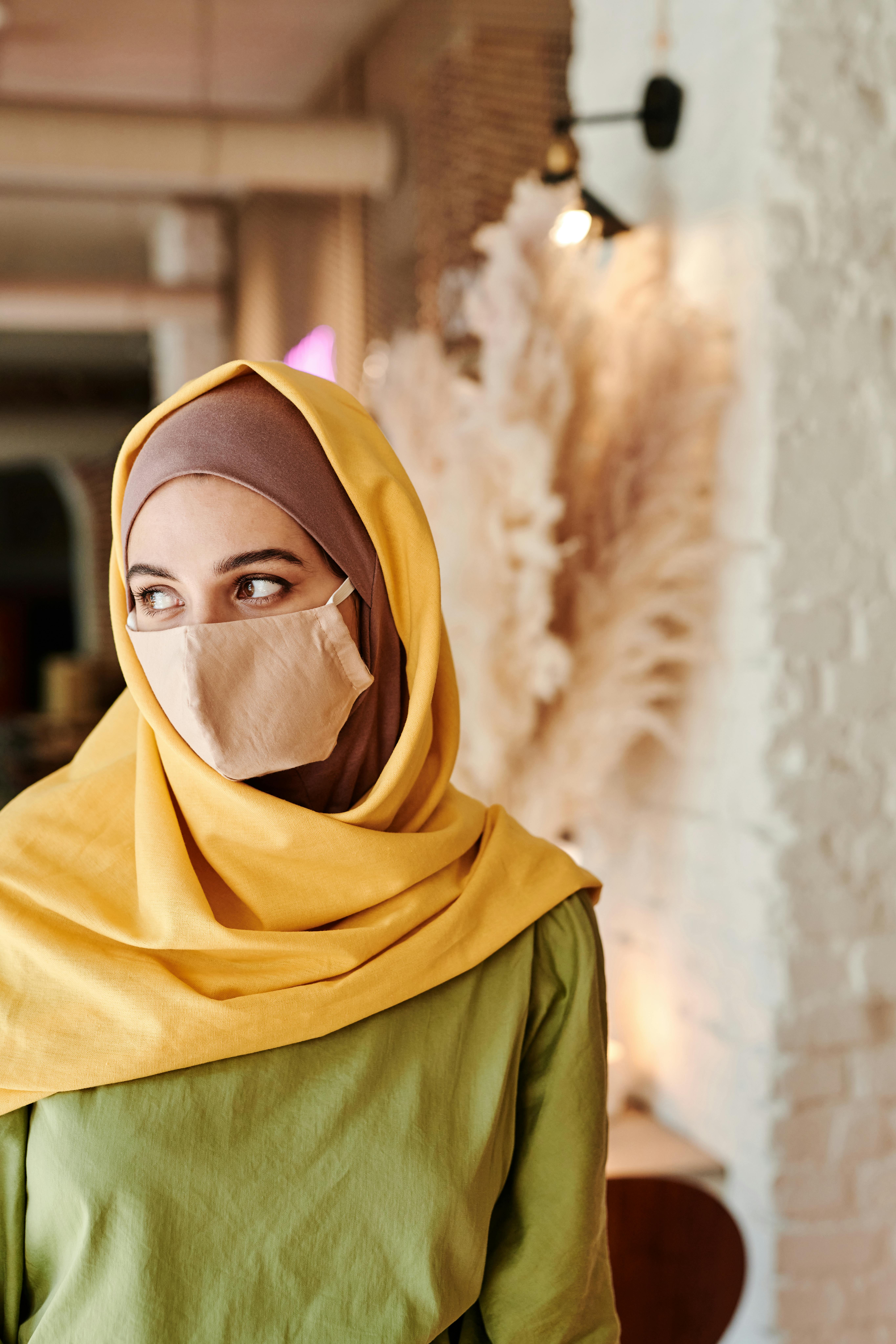 Woman in Yellow Hijab Wear Face Mask while Looking Afar · Free Stock Photo