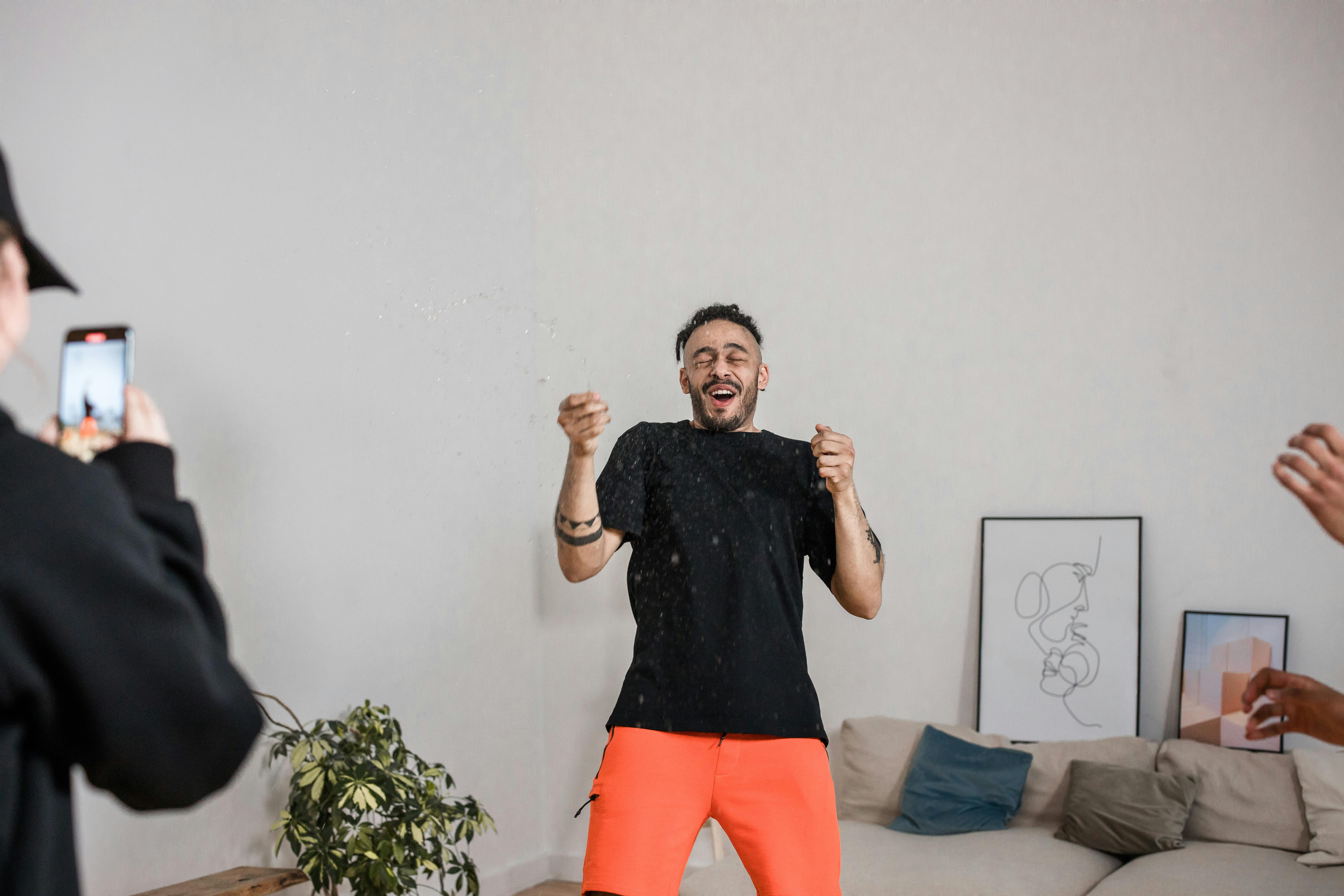 Person Taking a Video of Man in Black Shirt and Orange Short · Free ...