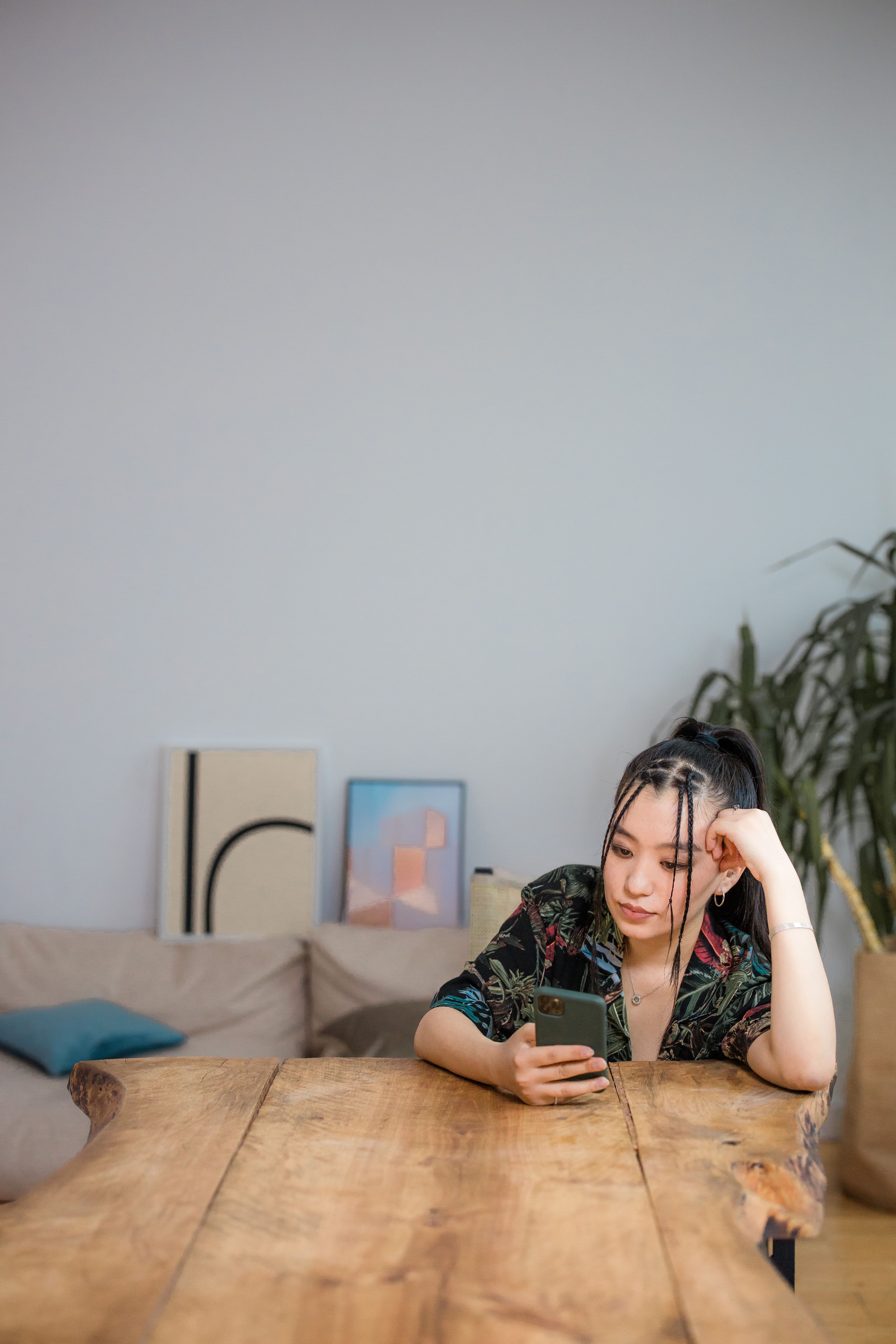 Woman Using Her Cellphone on Wooden Table · Free Stock Photo