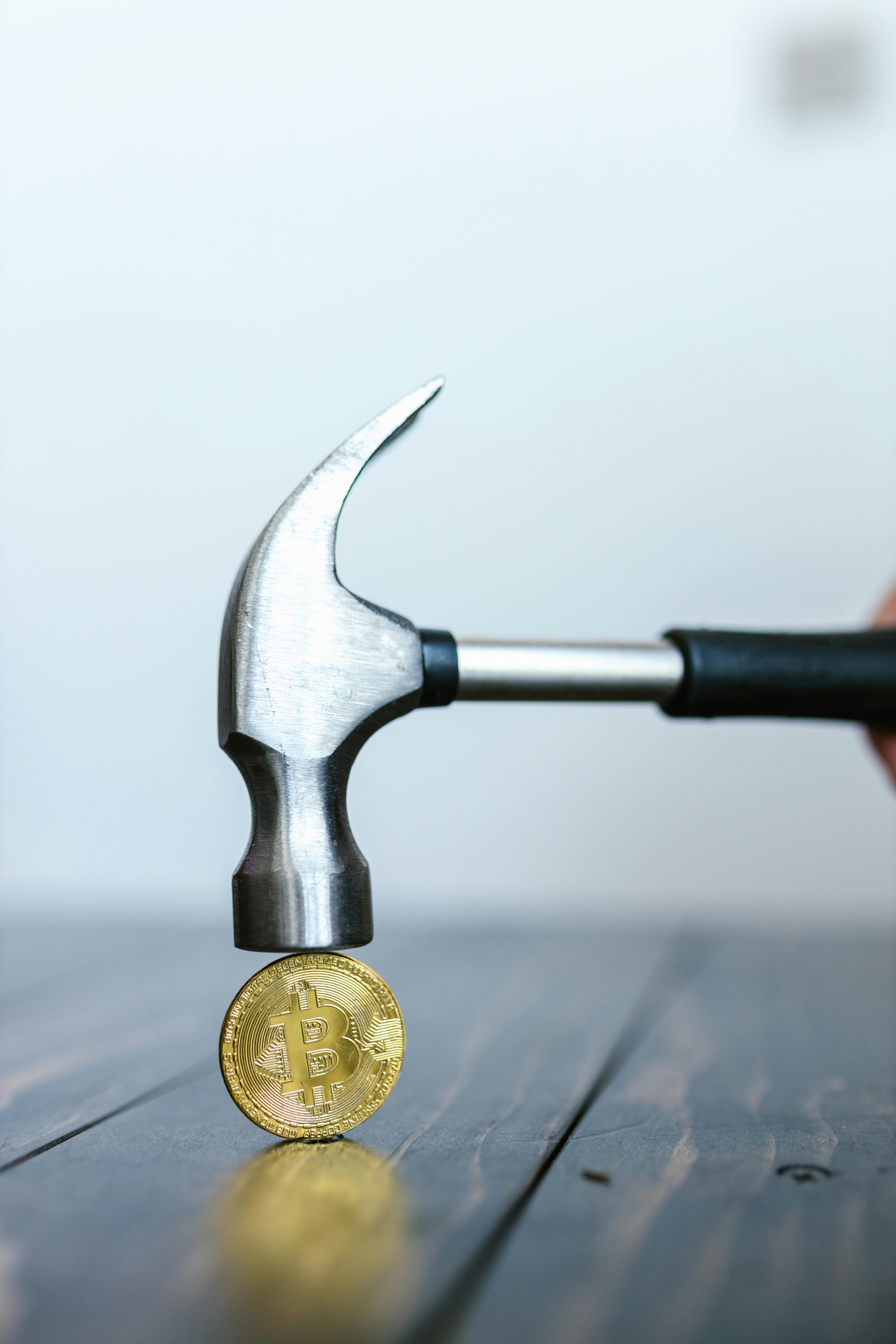 Person Knocking a Golden Bitcoin Token with a Hammer · Free Stock Photo