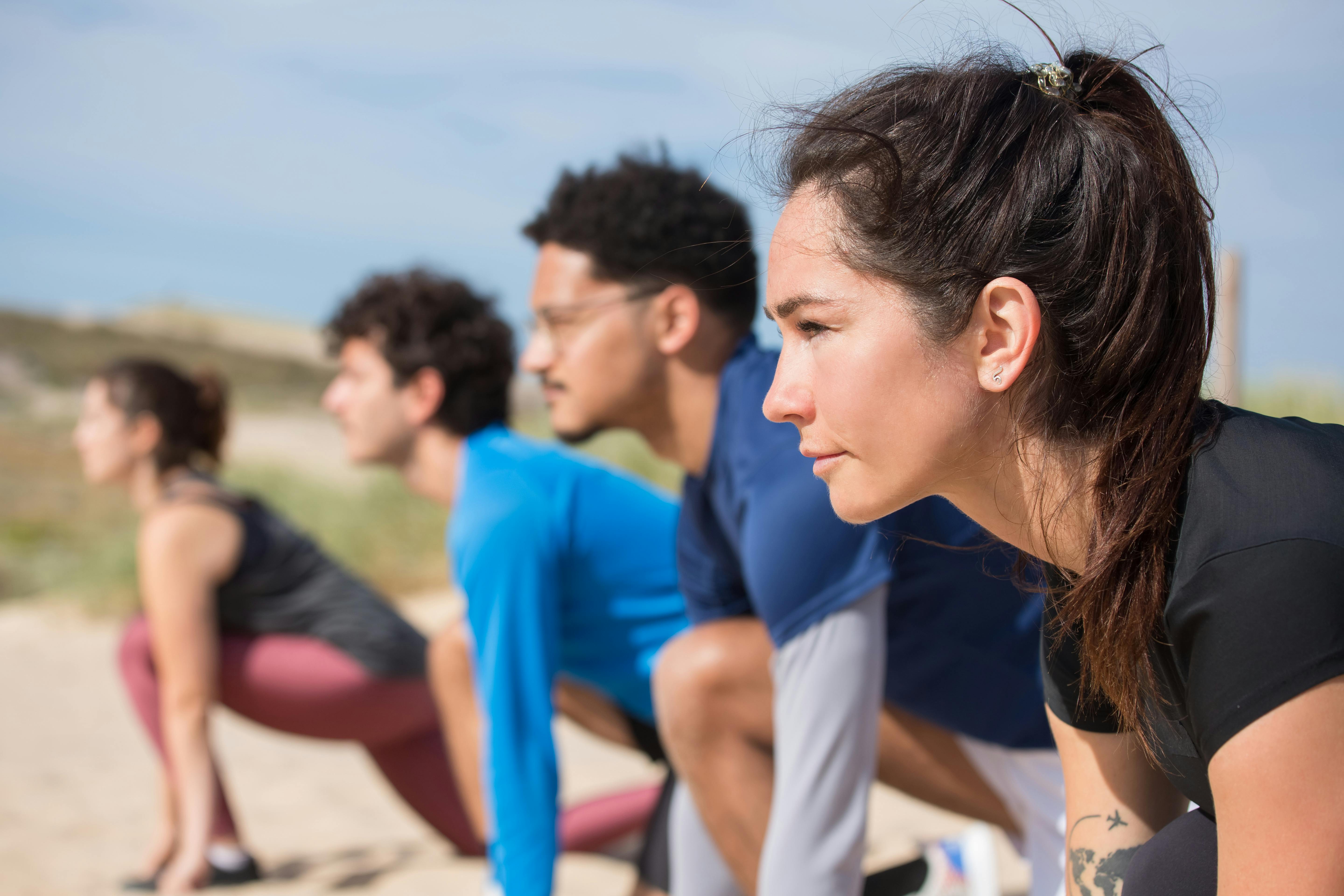 People Kneeling Together on Sand · Free Stock Photo