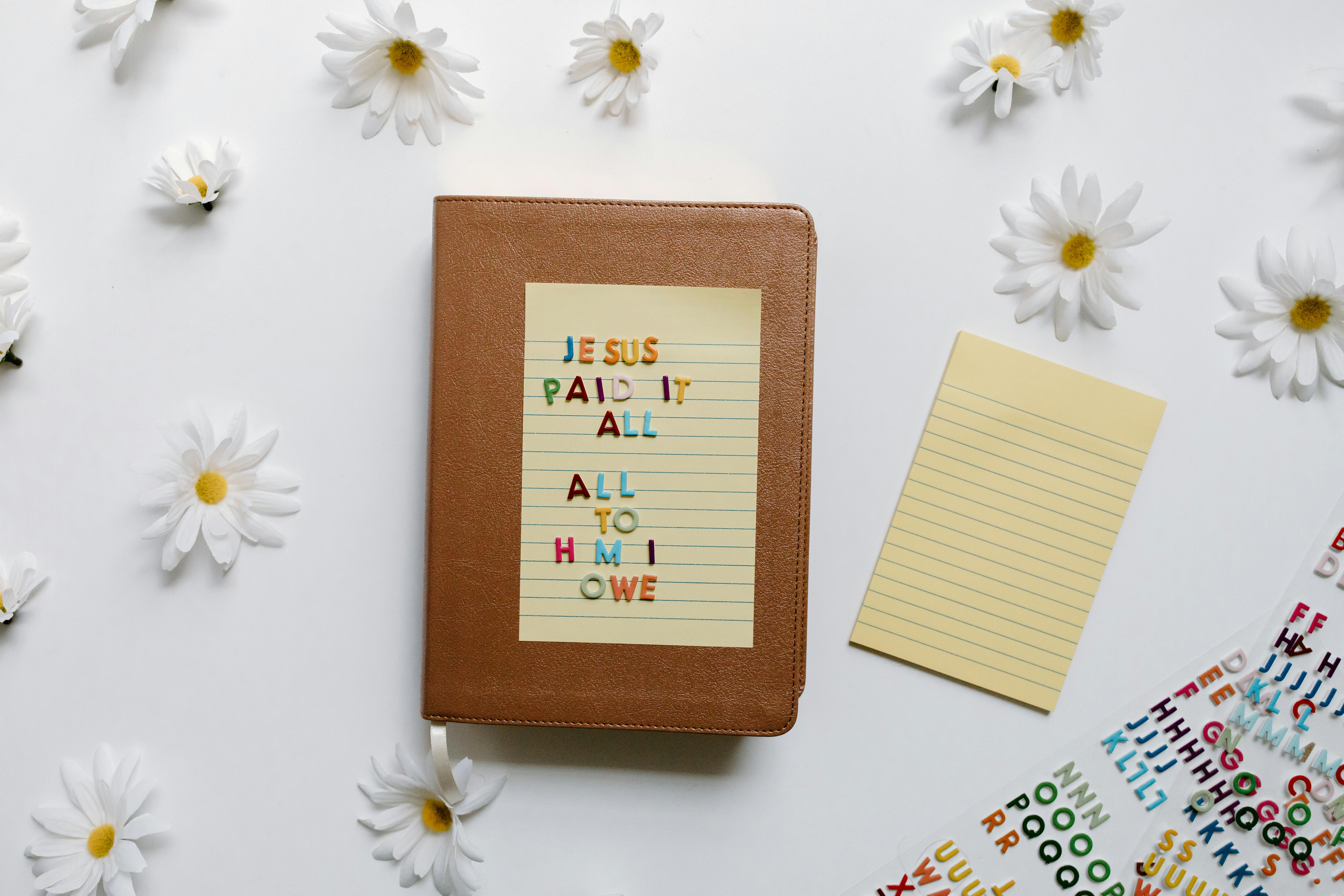 A Paper with Religious Quote on Brown Notebook · Free Stock Photo