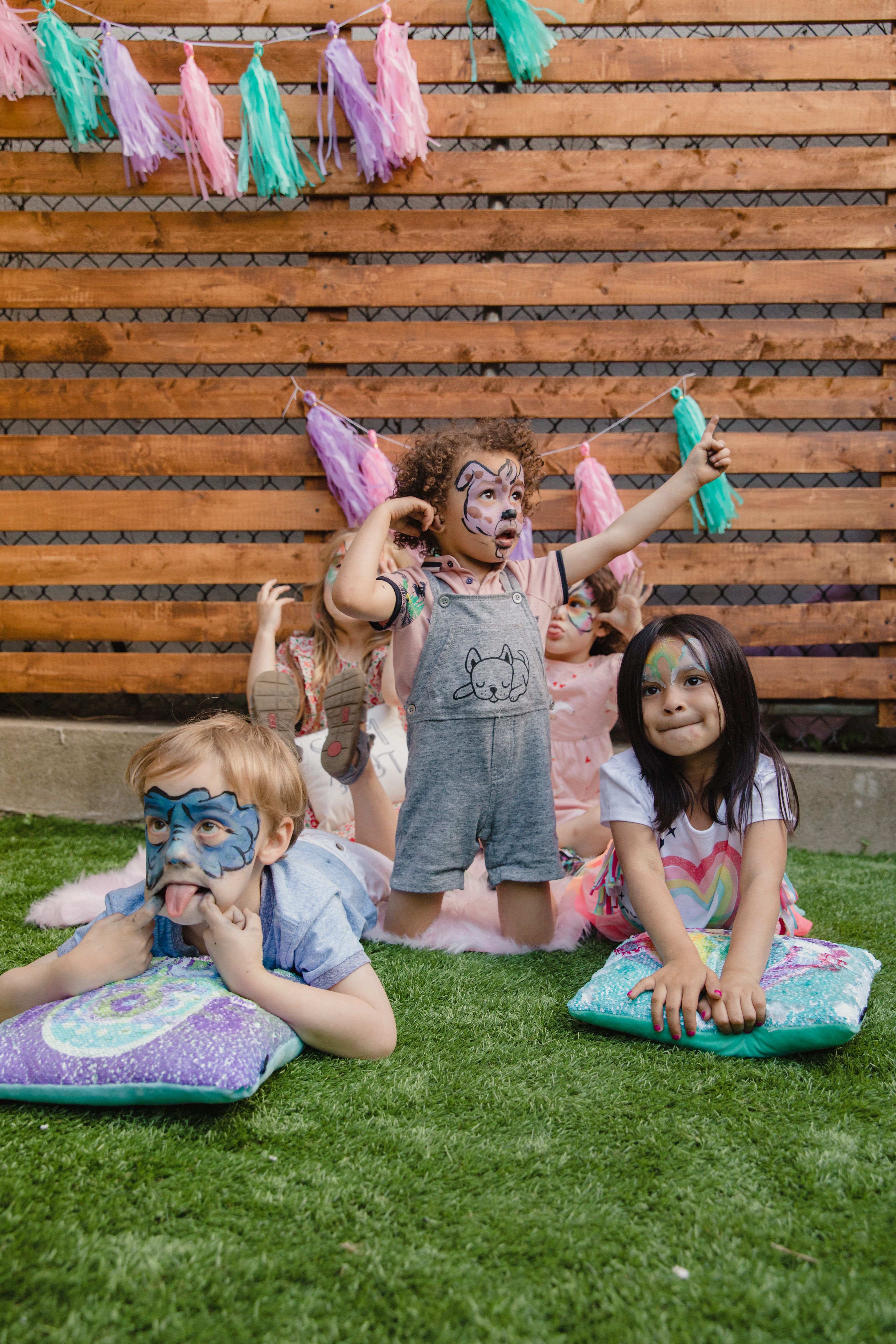 Kids on the Green Grass Near the Wooden Background · Free Stock Photo