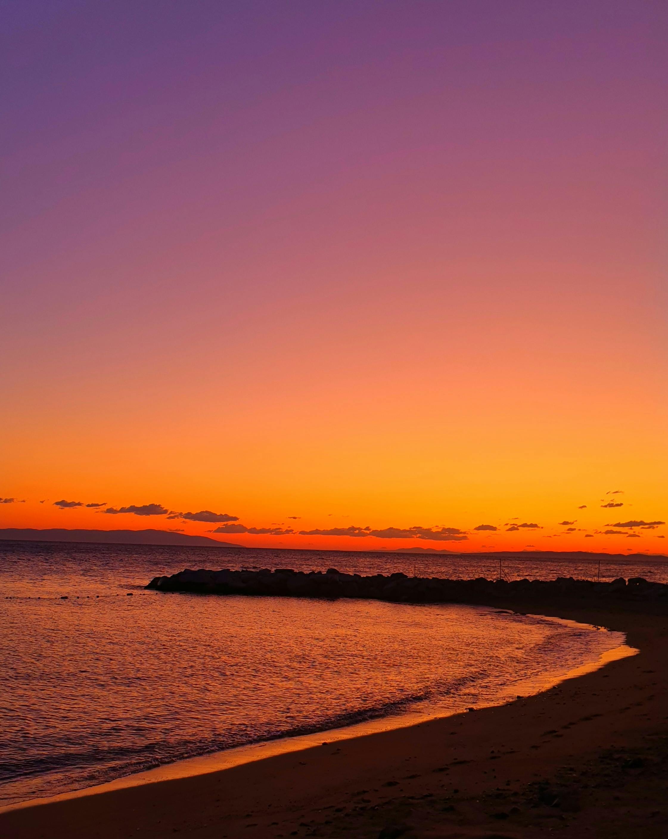 Wide Shot of an Ocean During Sunset · Free Stock Photo