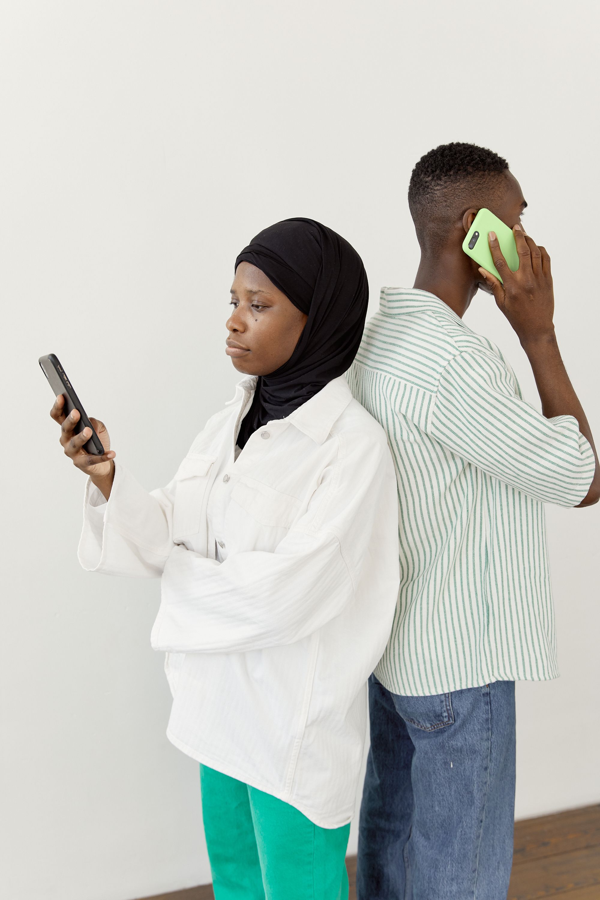 Woman and Man Standing Back to Back While Using Mobile Phones · Free ...