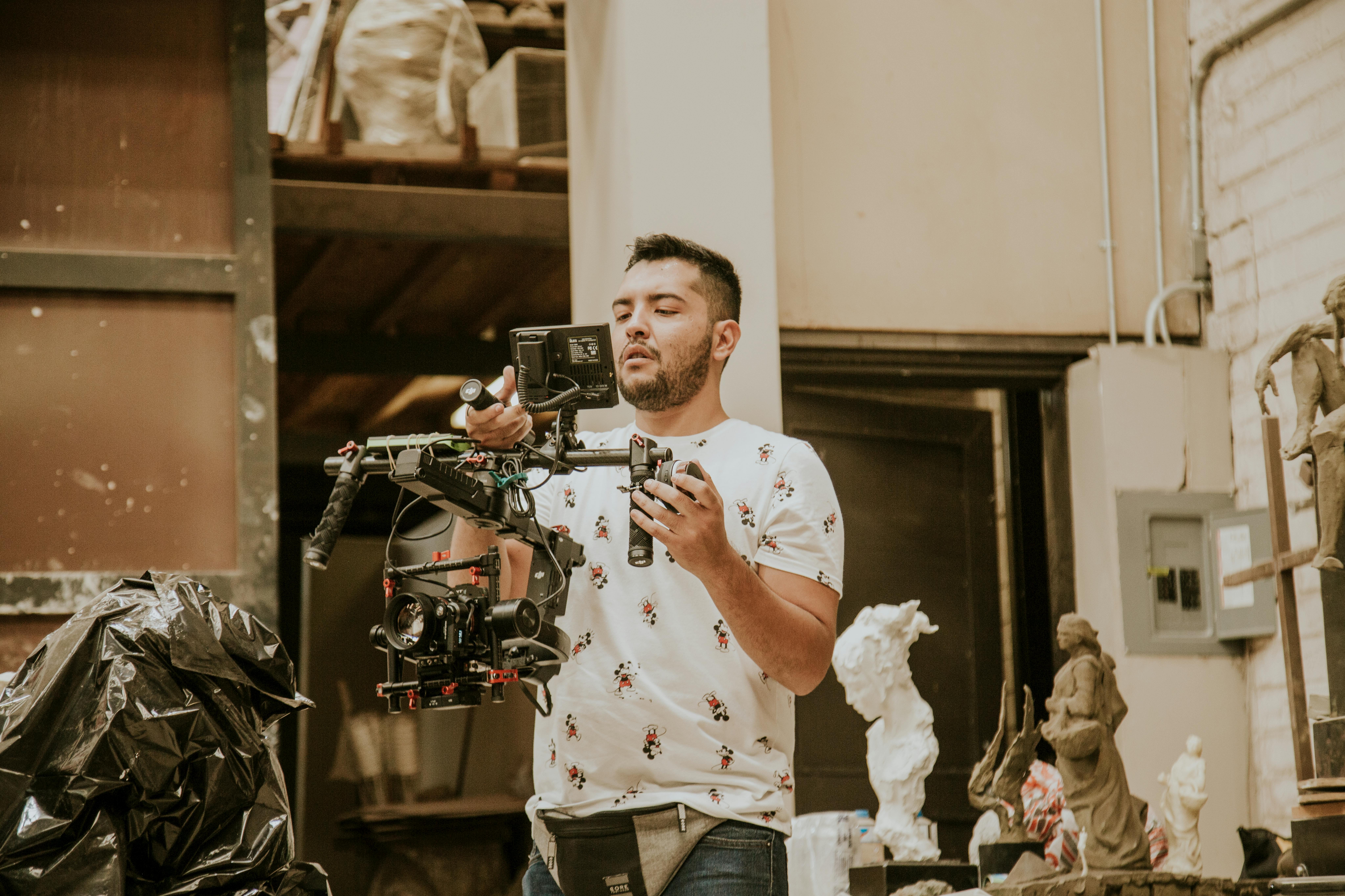 A Man in Brown jacket Holding Black Camera · Free Stock Photo