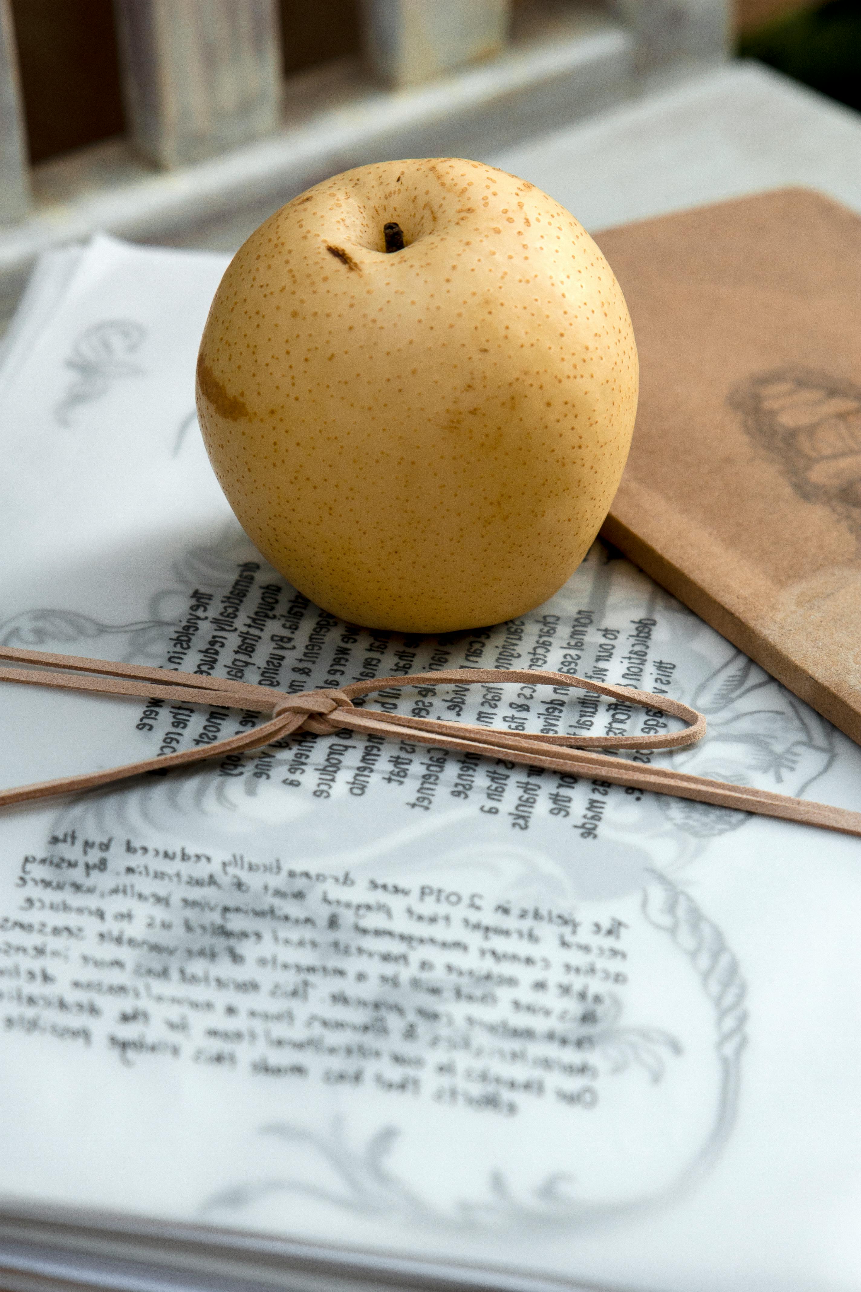 Close-Up Photo of Pear Fruit on top of Paper · Free Stock Photo