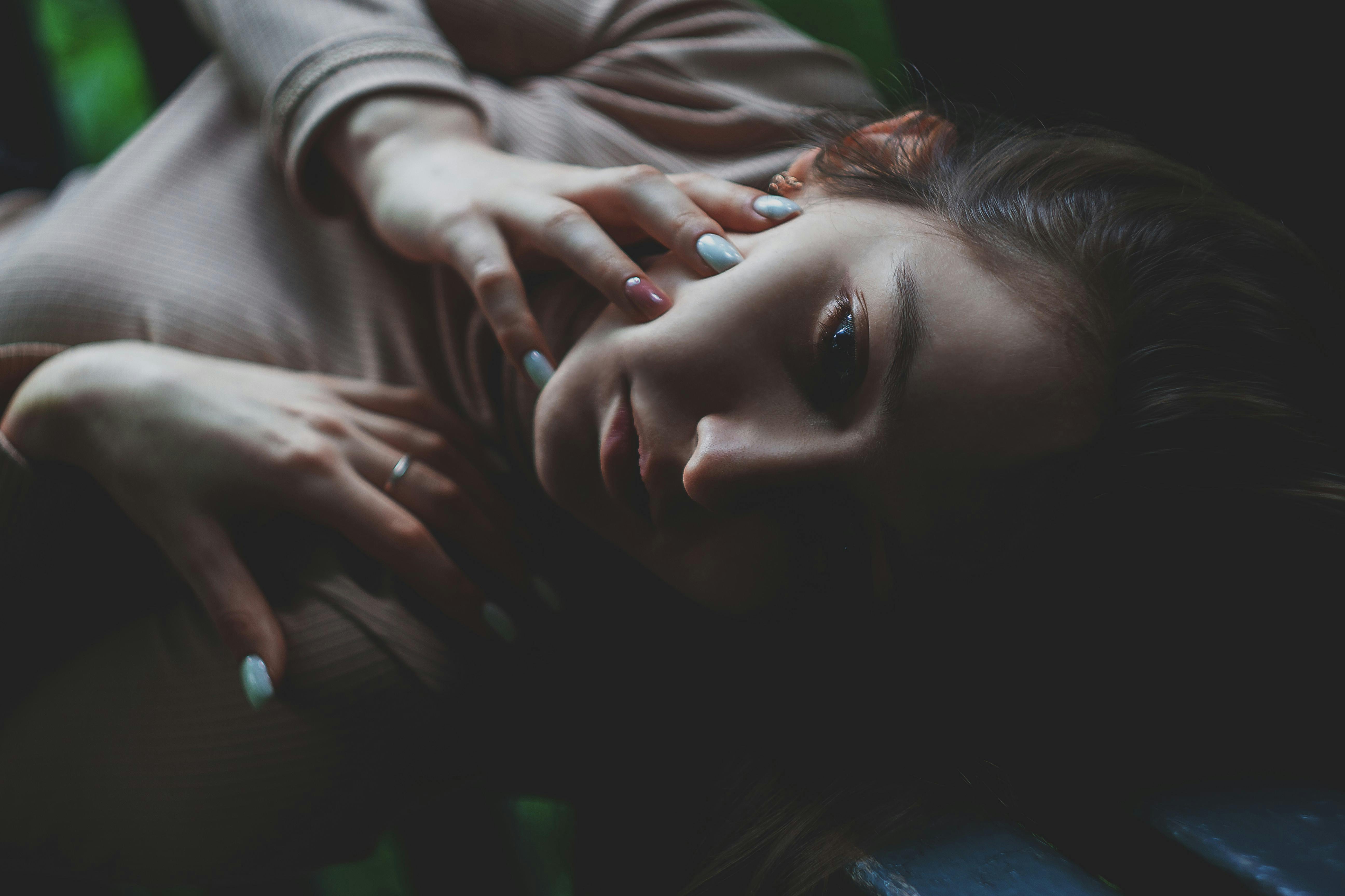 Woman Lying Down with Hand on Cheek · Free Stock Photo