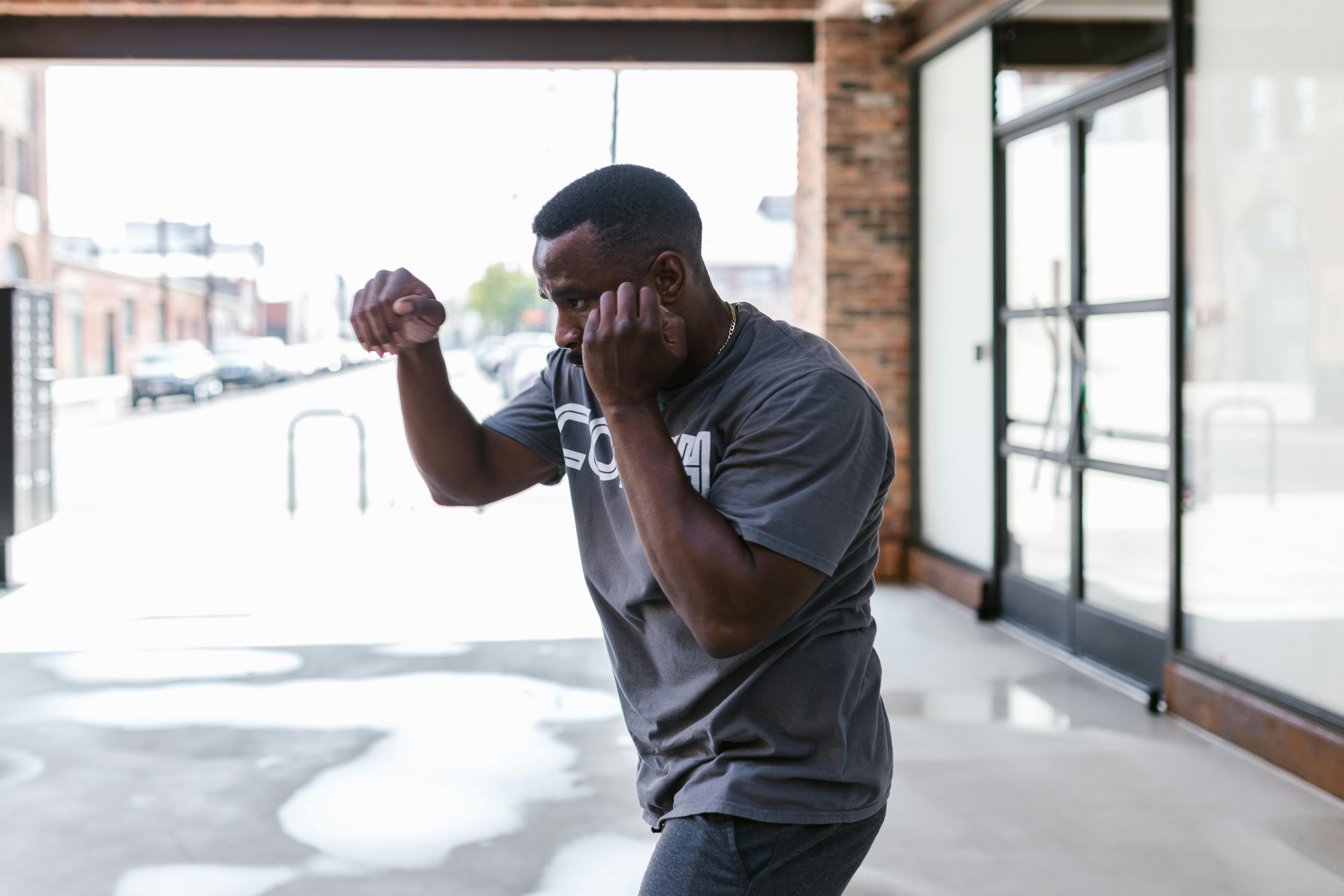 Man Wearing a Gray Shirt Doing Shadow Boxing · Free Stock Photo