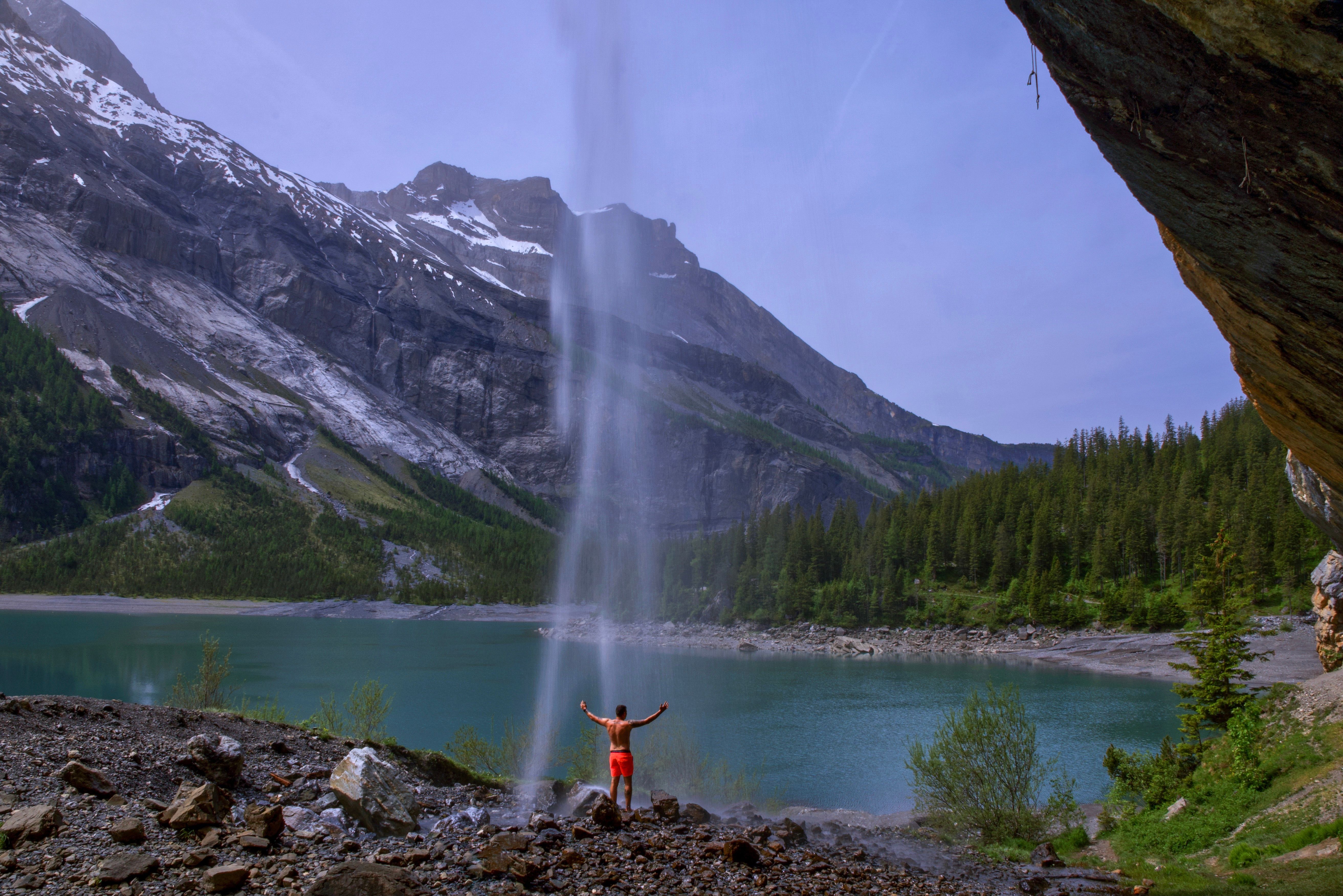 Person Standing Under a Waterfalls · Free Stock Photo