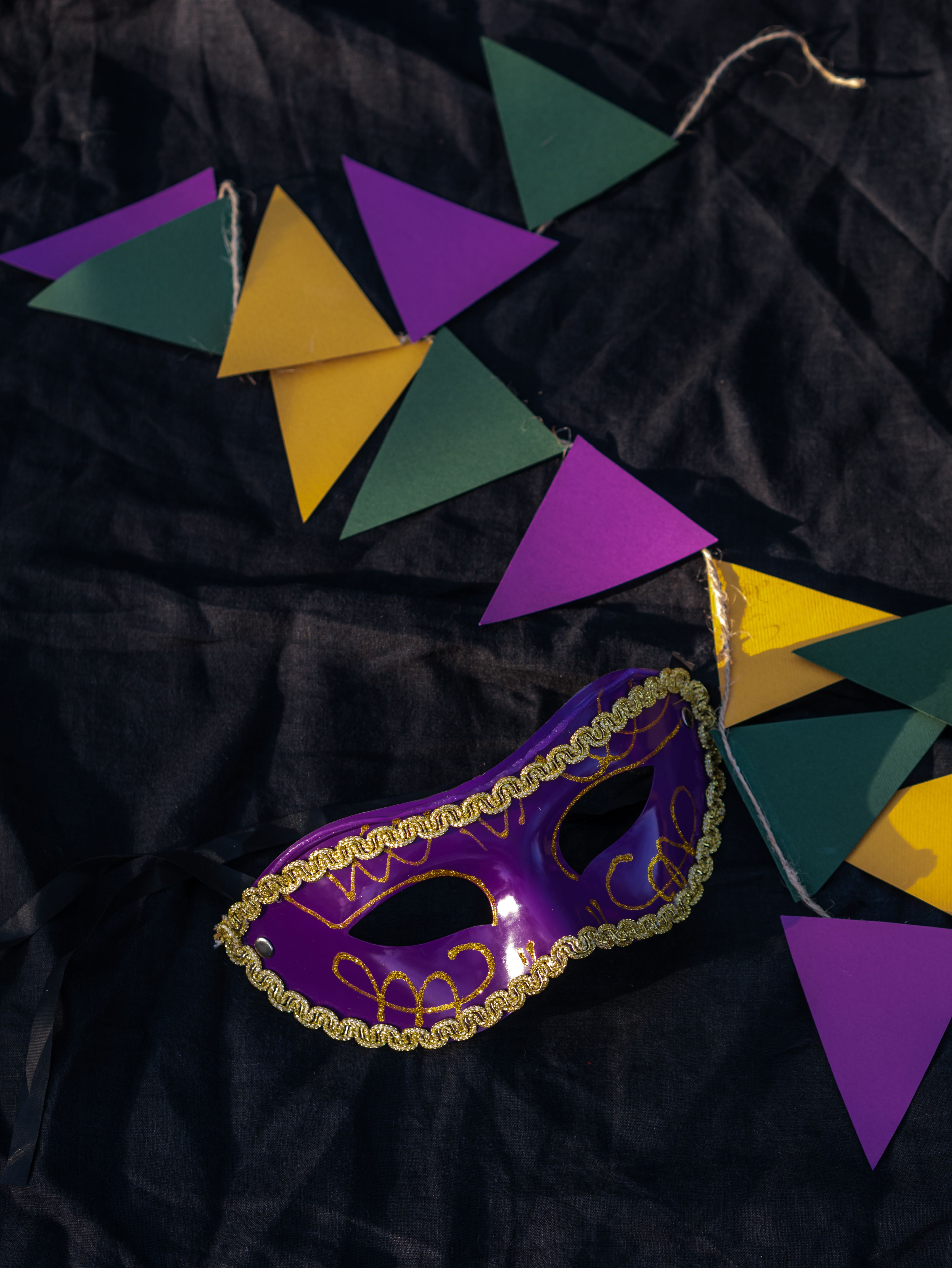 A Purple Mask Beside Colorful Banderitas on a Black Surface · Free ...