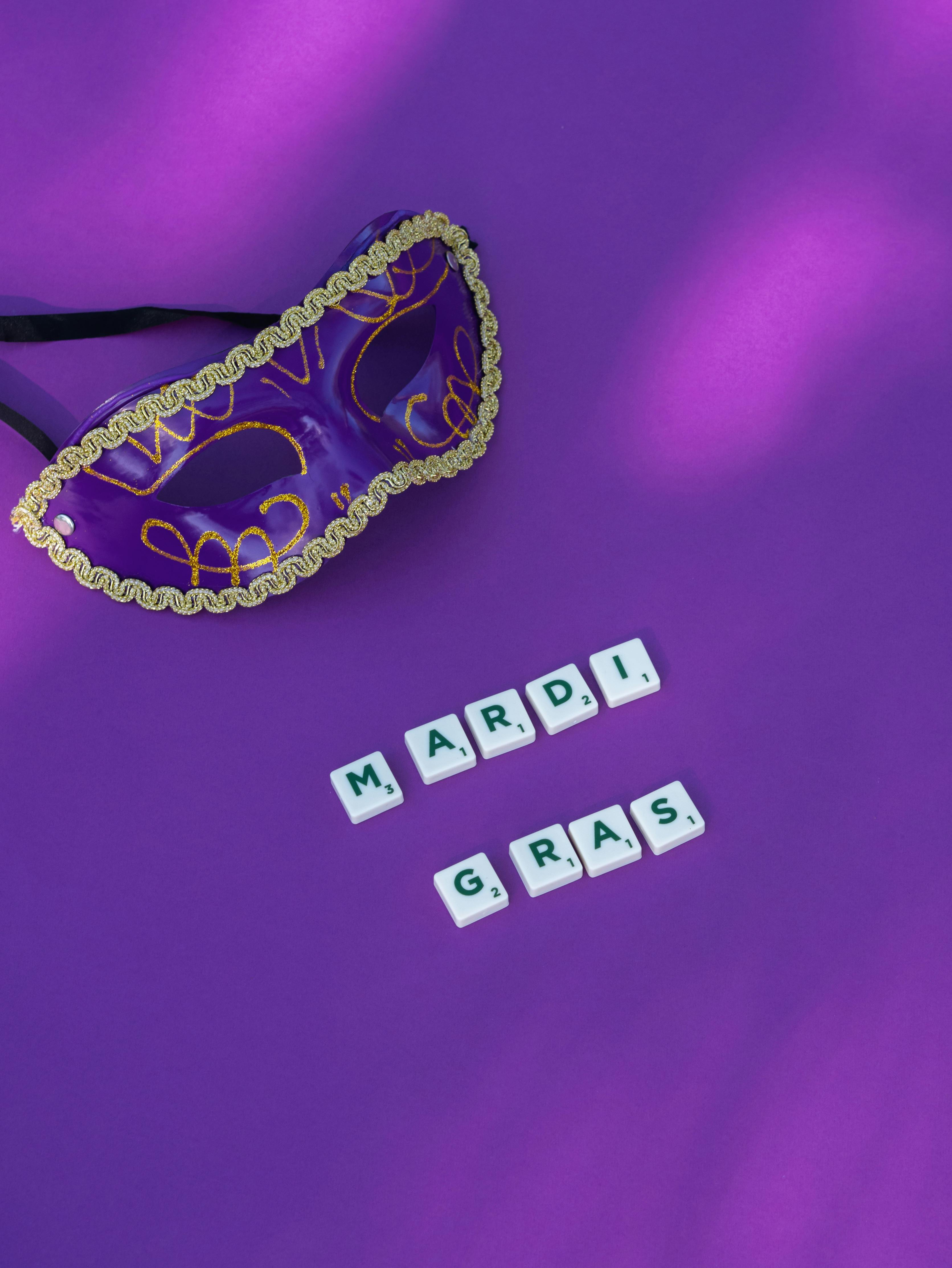 A Mask Beside Scrabble Tiles on a Purple Surface · Free Stock Photo