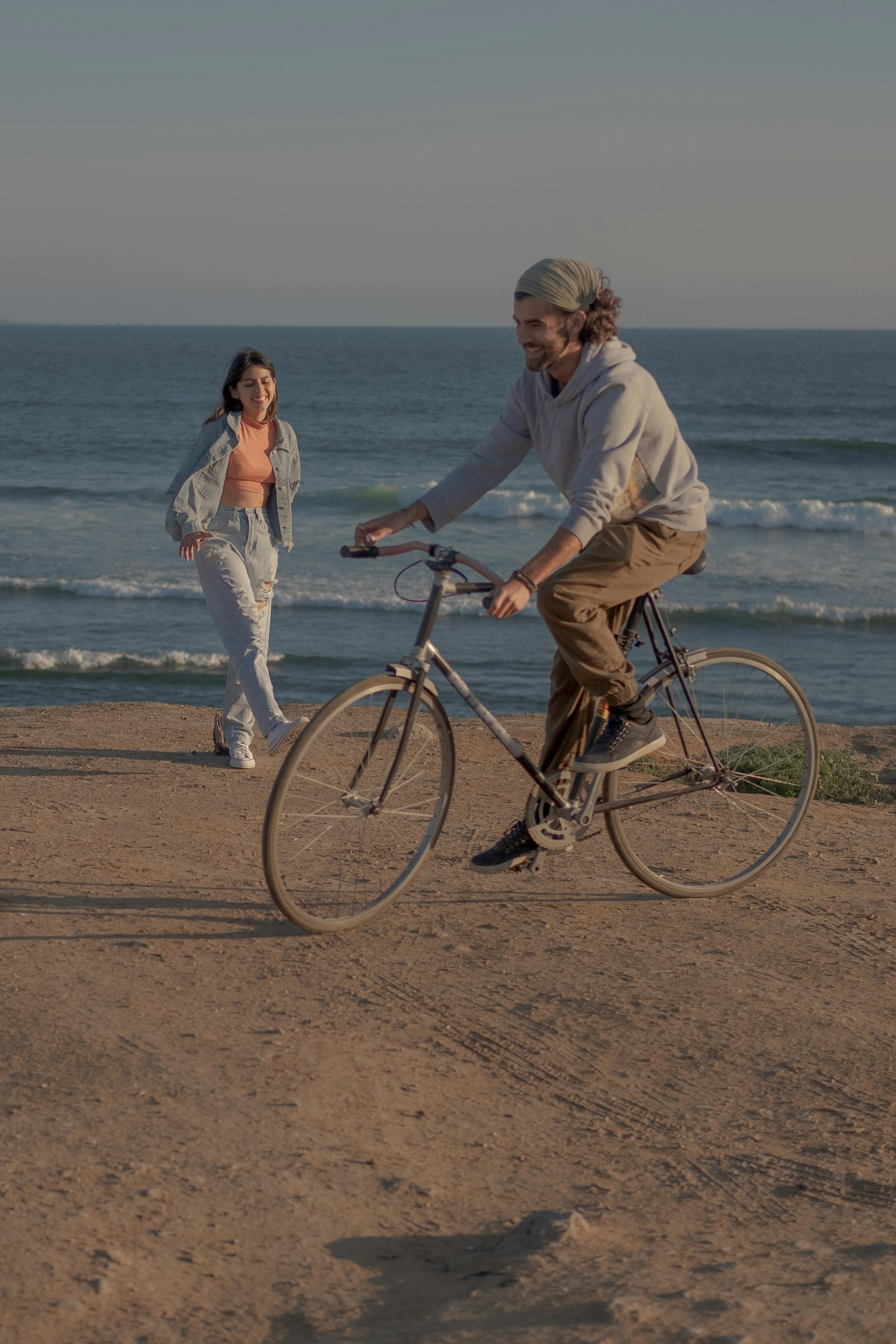A Man Riding a Bicycle on the Beach · Free Stock Photo