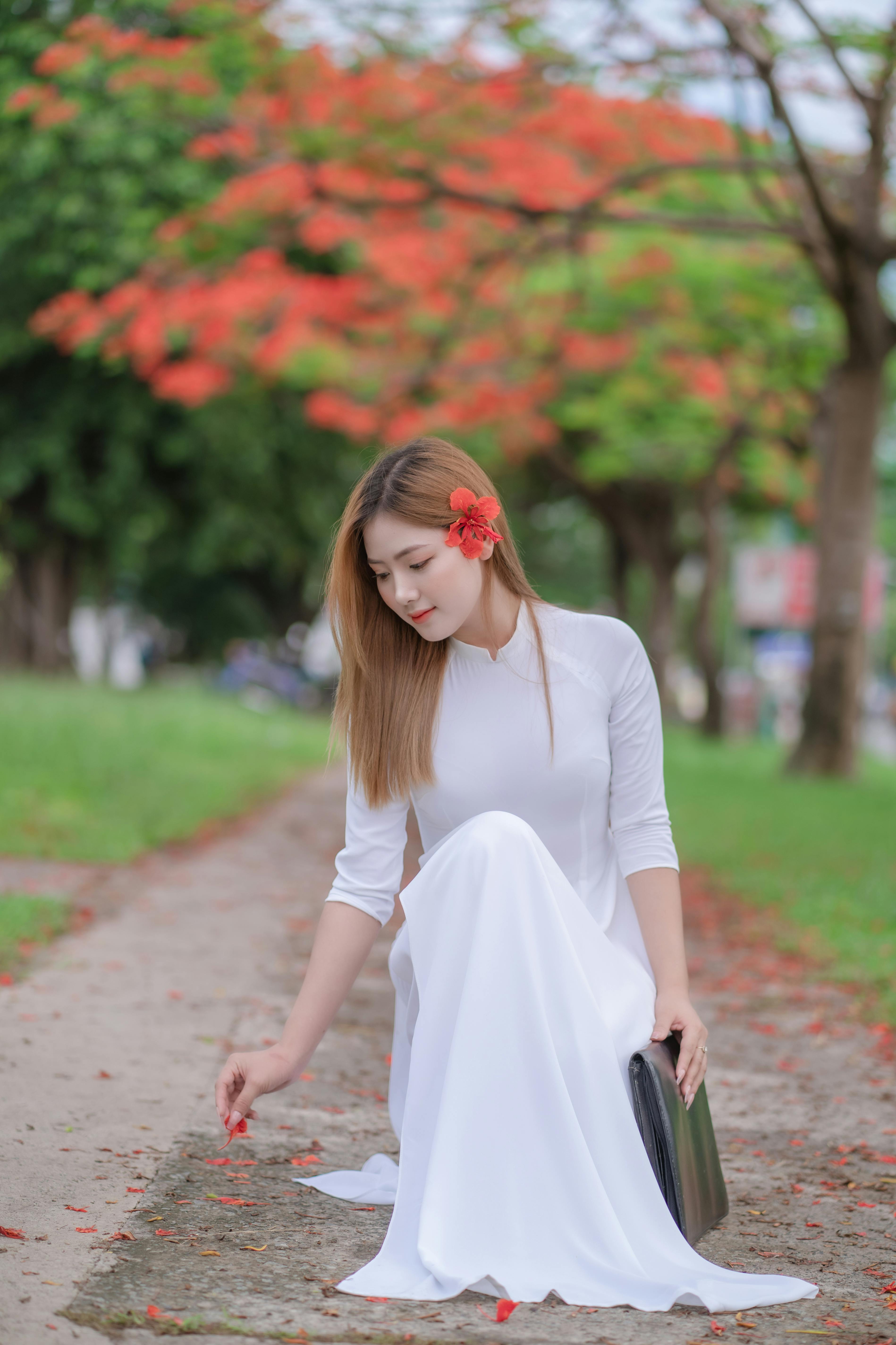 Woman in Orange Dress Leaning on Concrete Railing · Free Stock Photo
