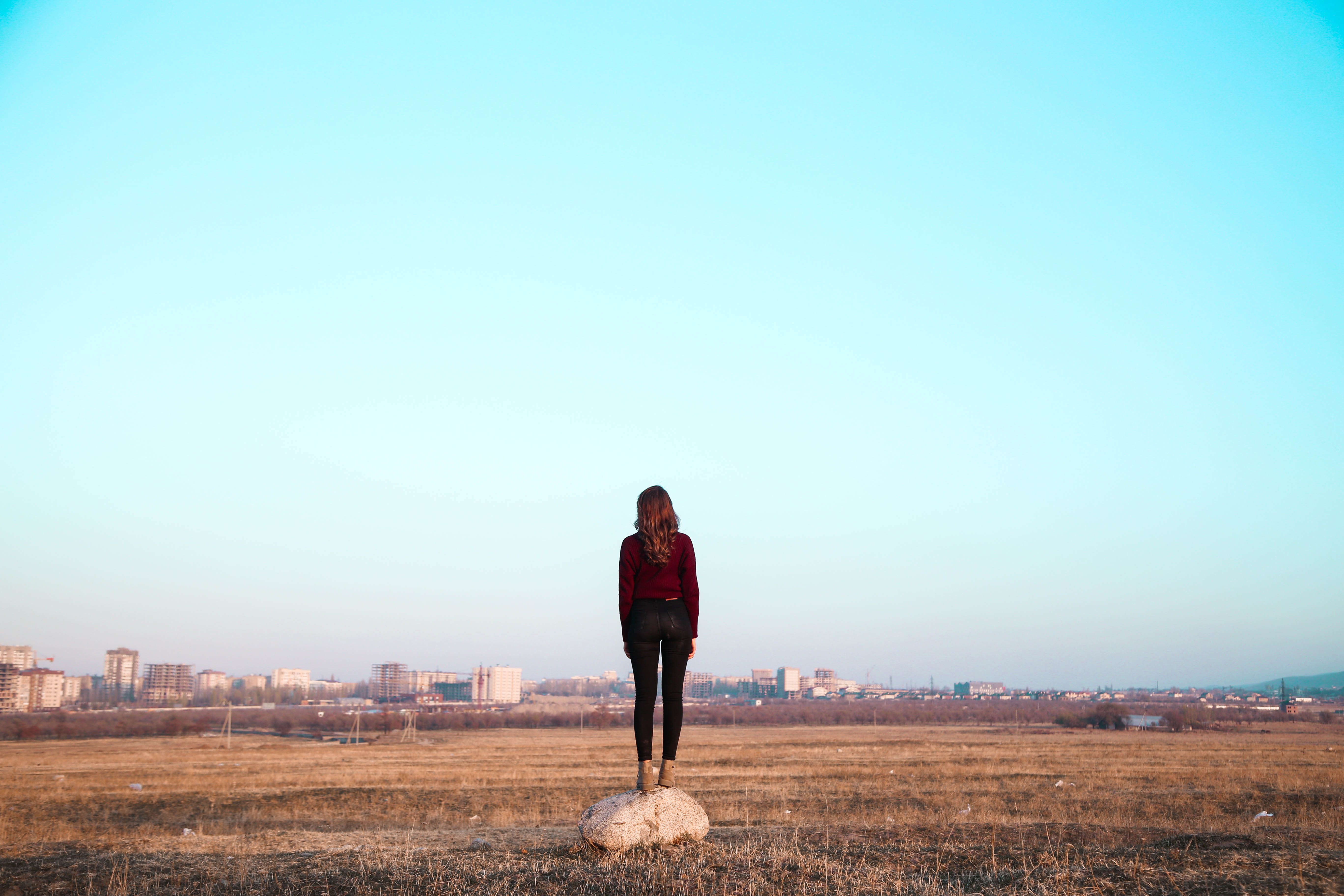 Woman Wearing Yellow and Red Dress Sitting on the Ground While Looking ...
