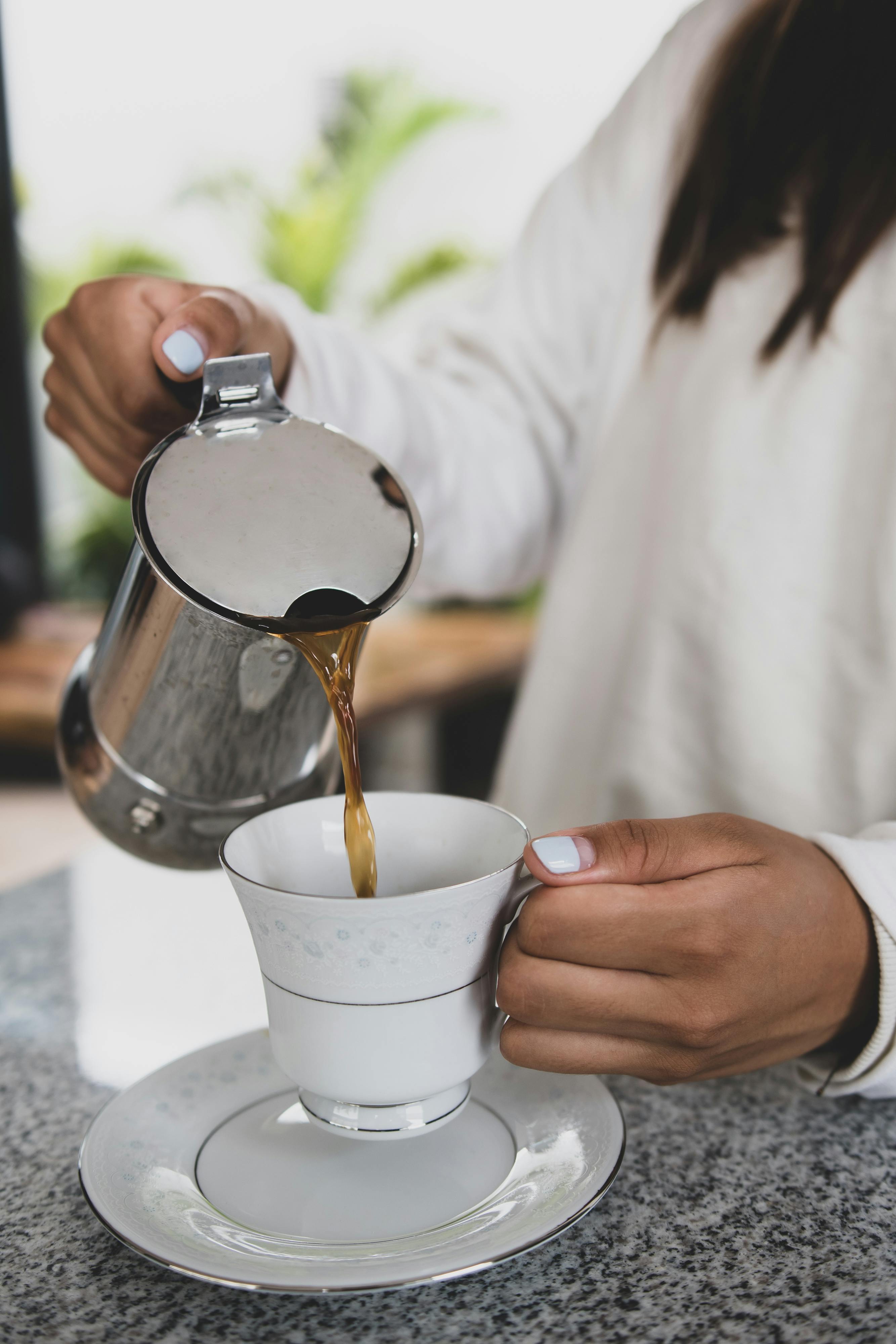 A Person Pouring Tea in the Cup · Free Stock Photo
