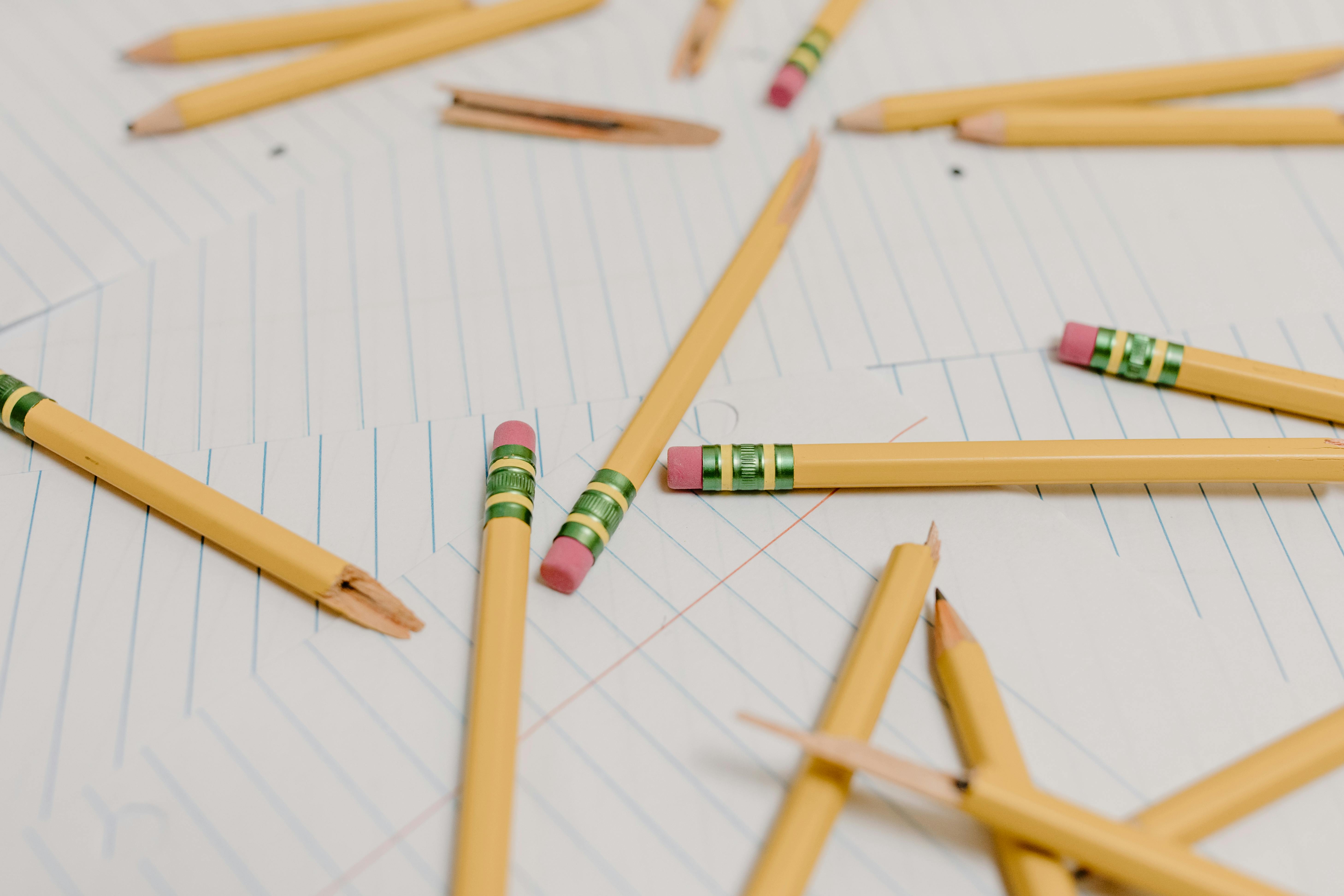 Close-Up Photo of Broken Pencils on White Paper · Free Stock Photo