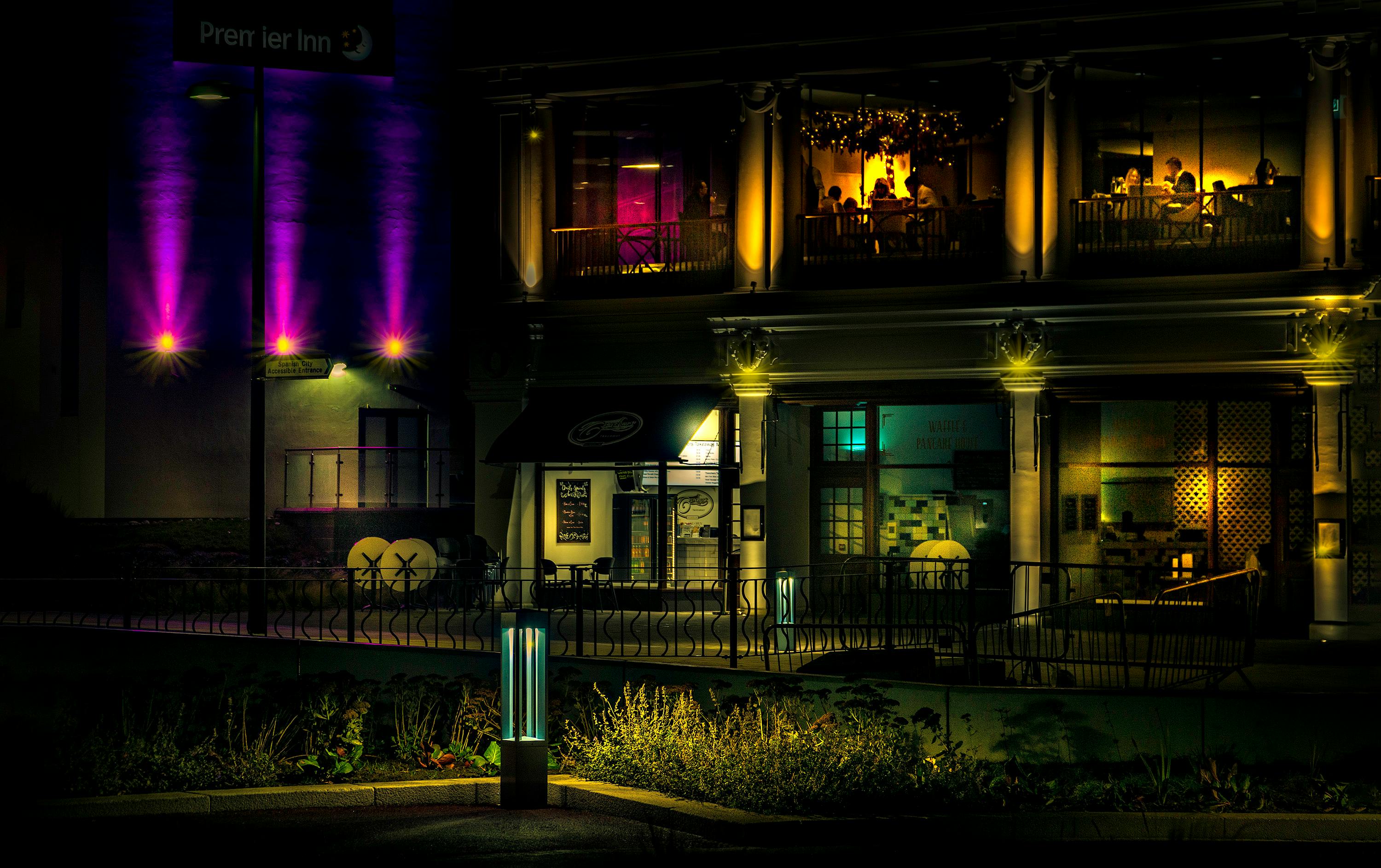 A Restaurant In A Building With Lights At Nighttime · Free Stock Photo