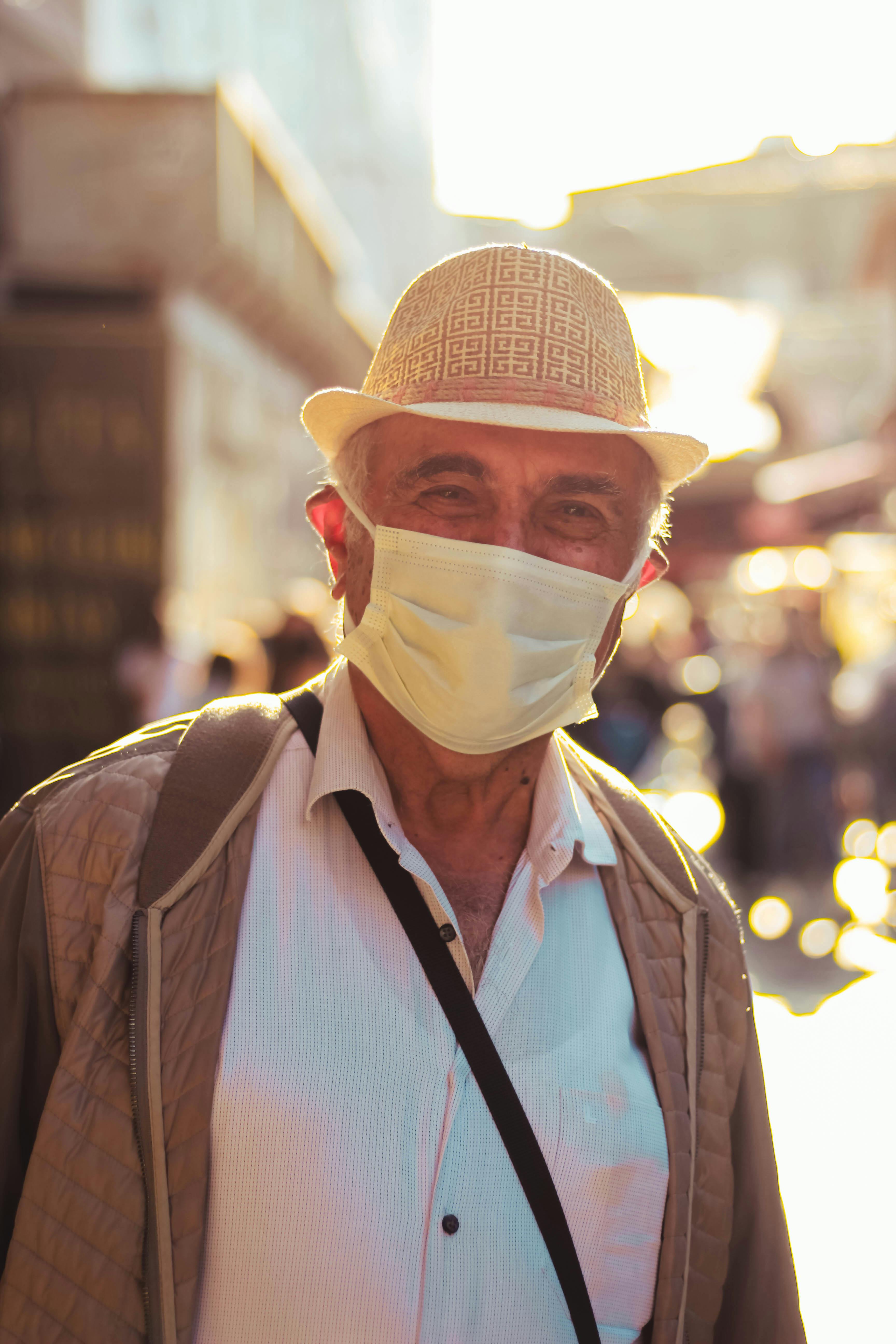 Portrait of a Man Wearing a Hat and a White Face Mask · Free Stock Photo