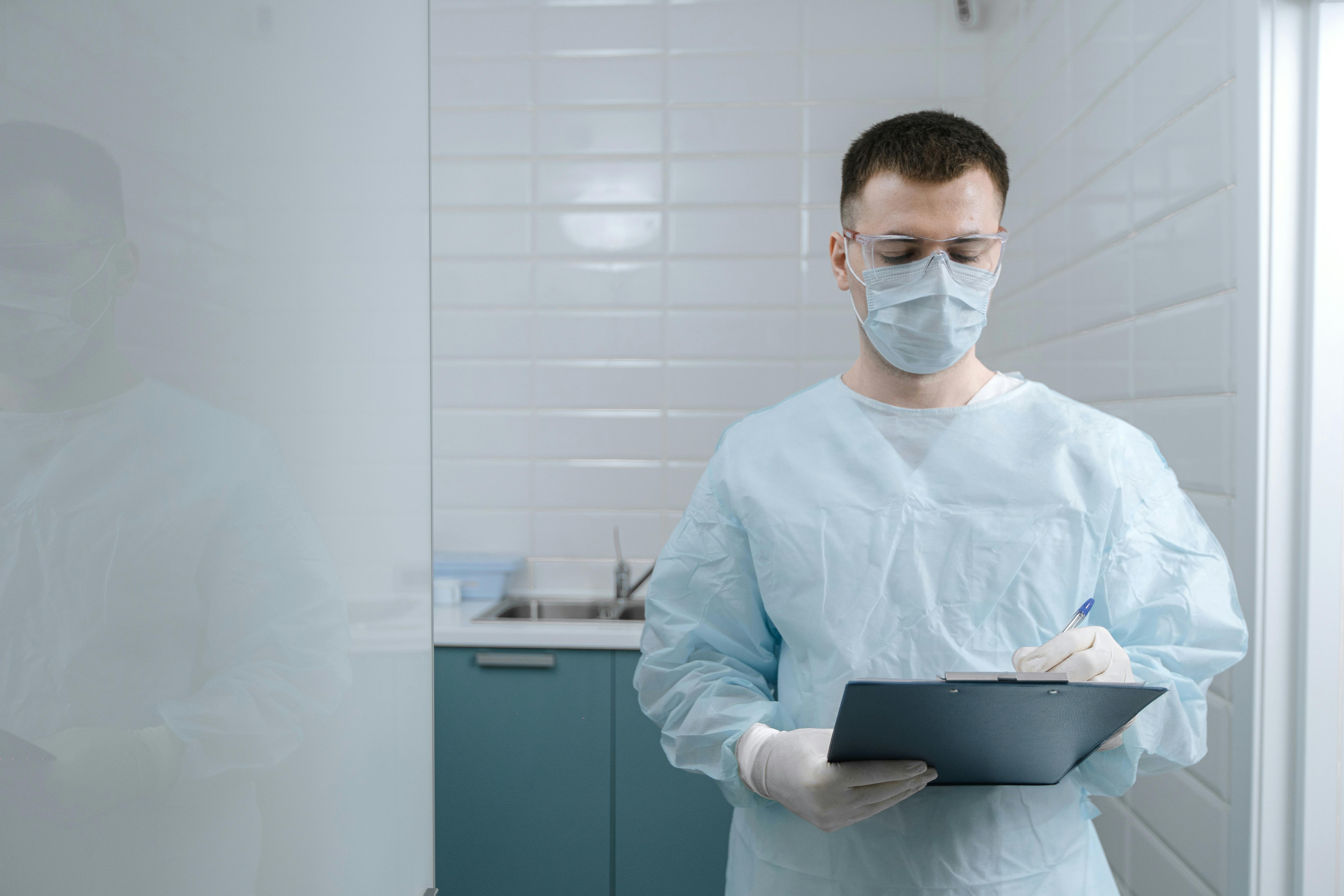 A Doctor with Stethoscope Wearing Pink Face Mask while Looking at the ...