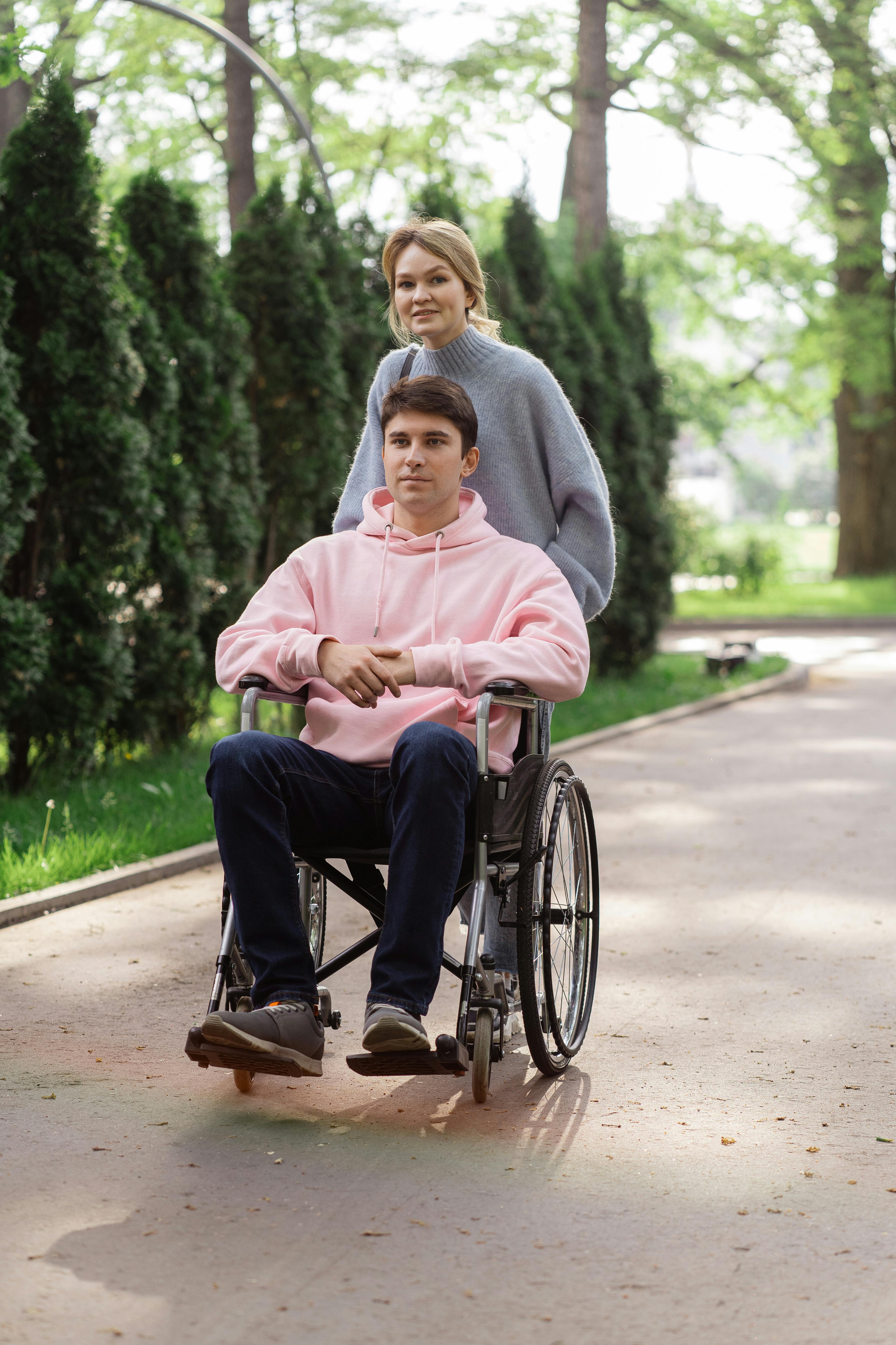 Woman Pushing the Wheelchair with a Man · Free Stock Photo
