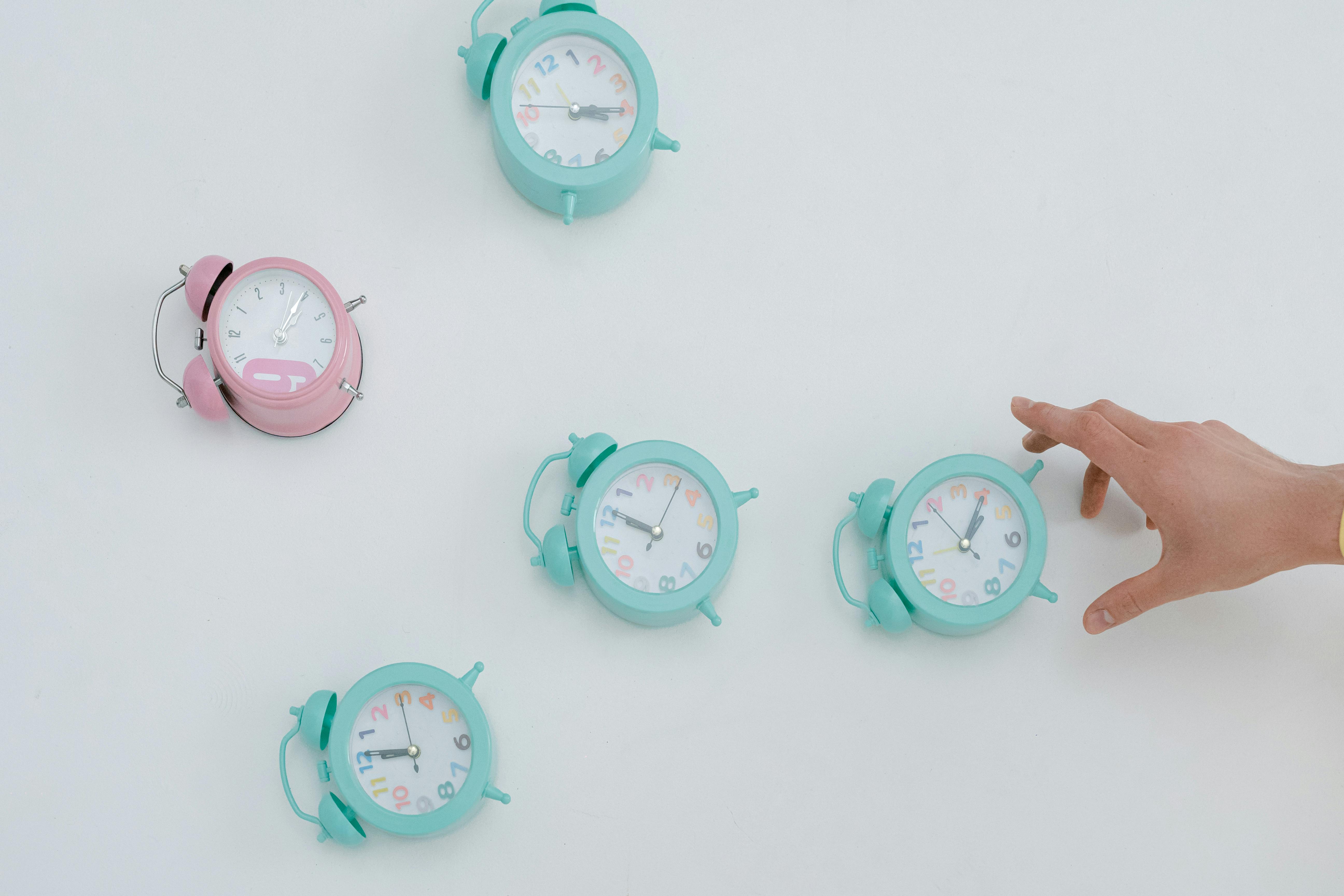 Hand over Alarm Clocks · Free Stock Photo