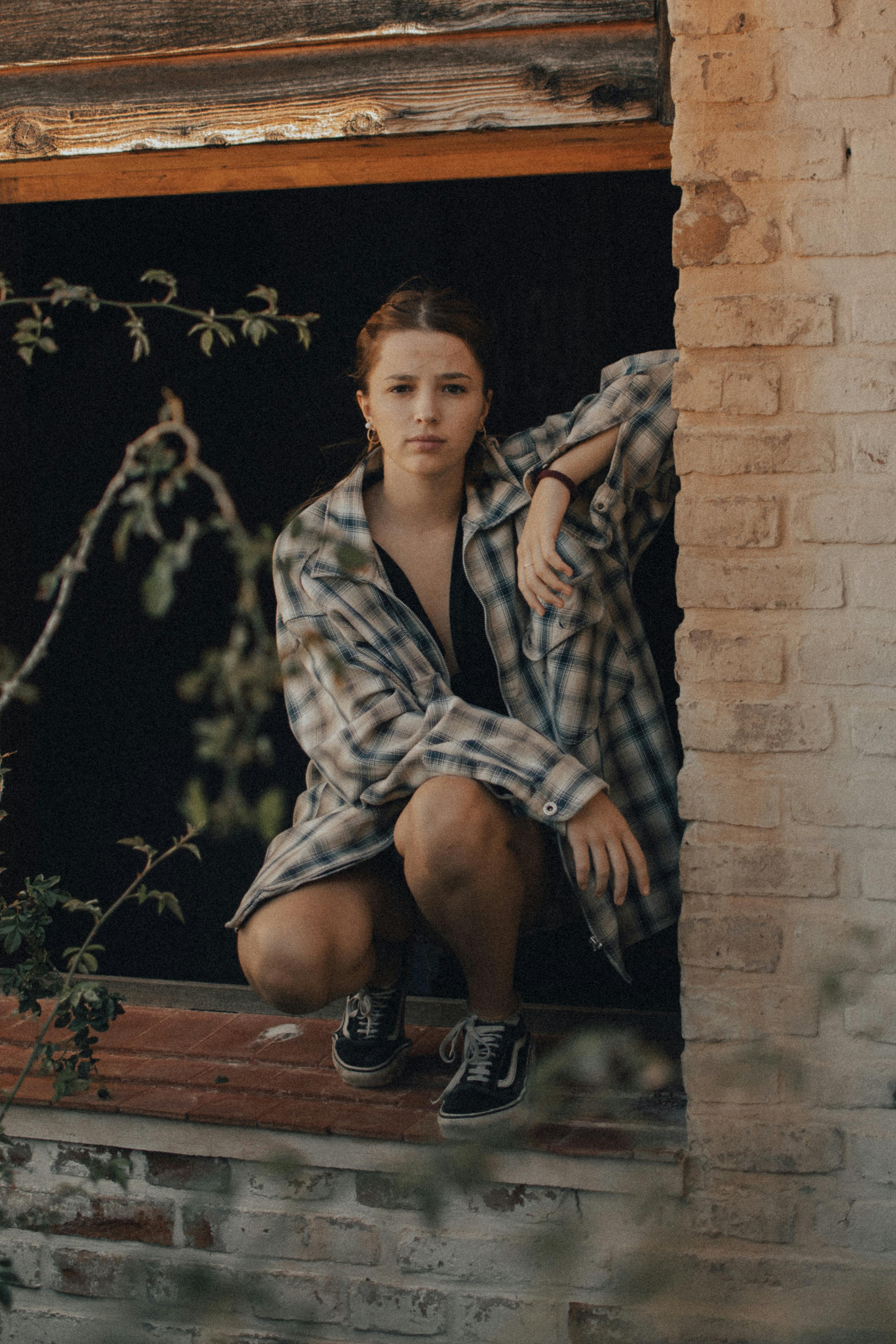 Photo of Posing Woman Sitting on Window Sill · Free Stock Photo