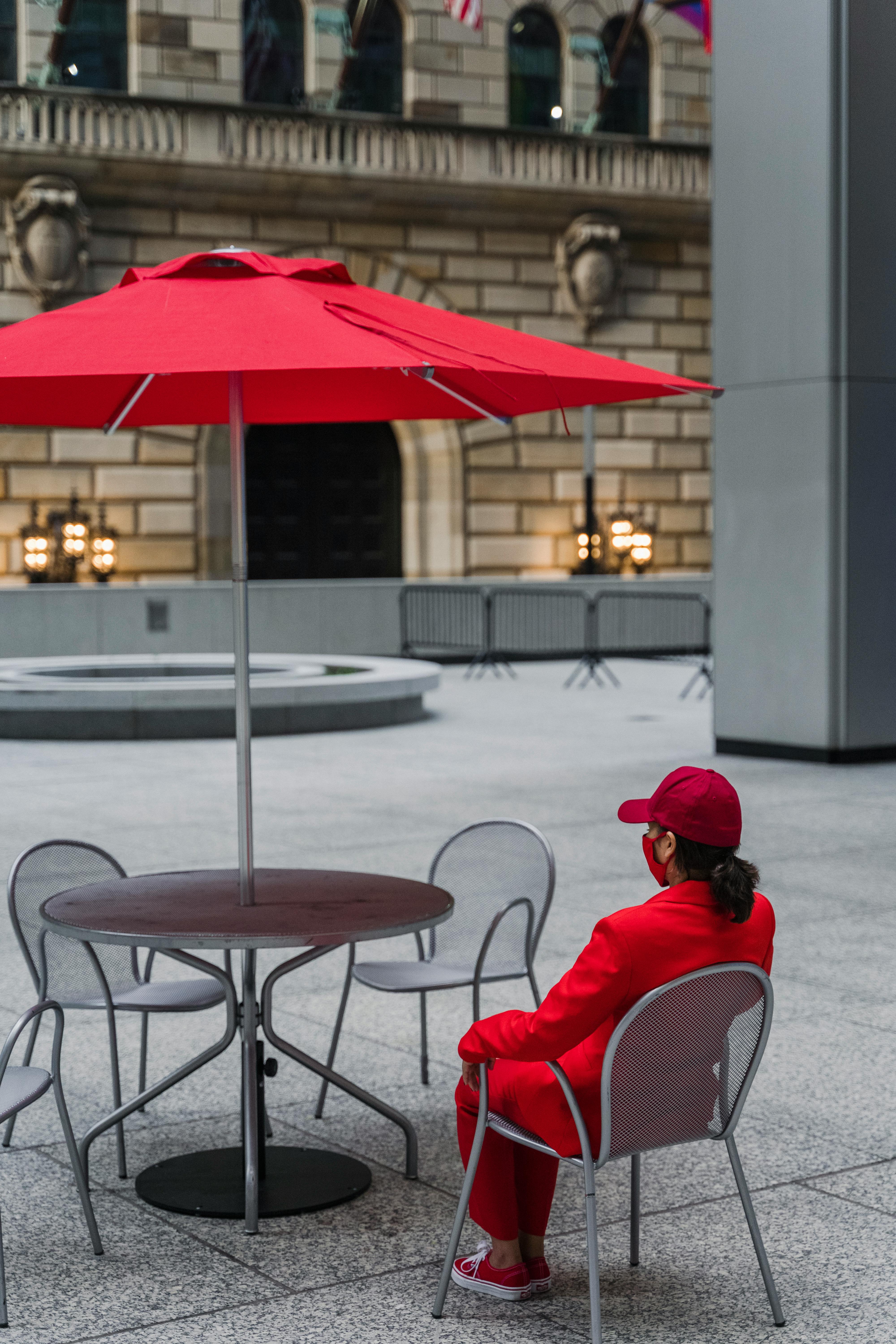 A Person Wearing Red Clothes Sitting on a Metal Chair · Free Stock Photo