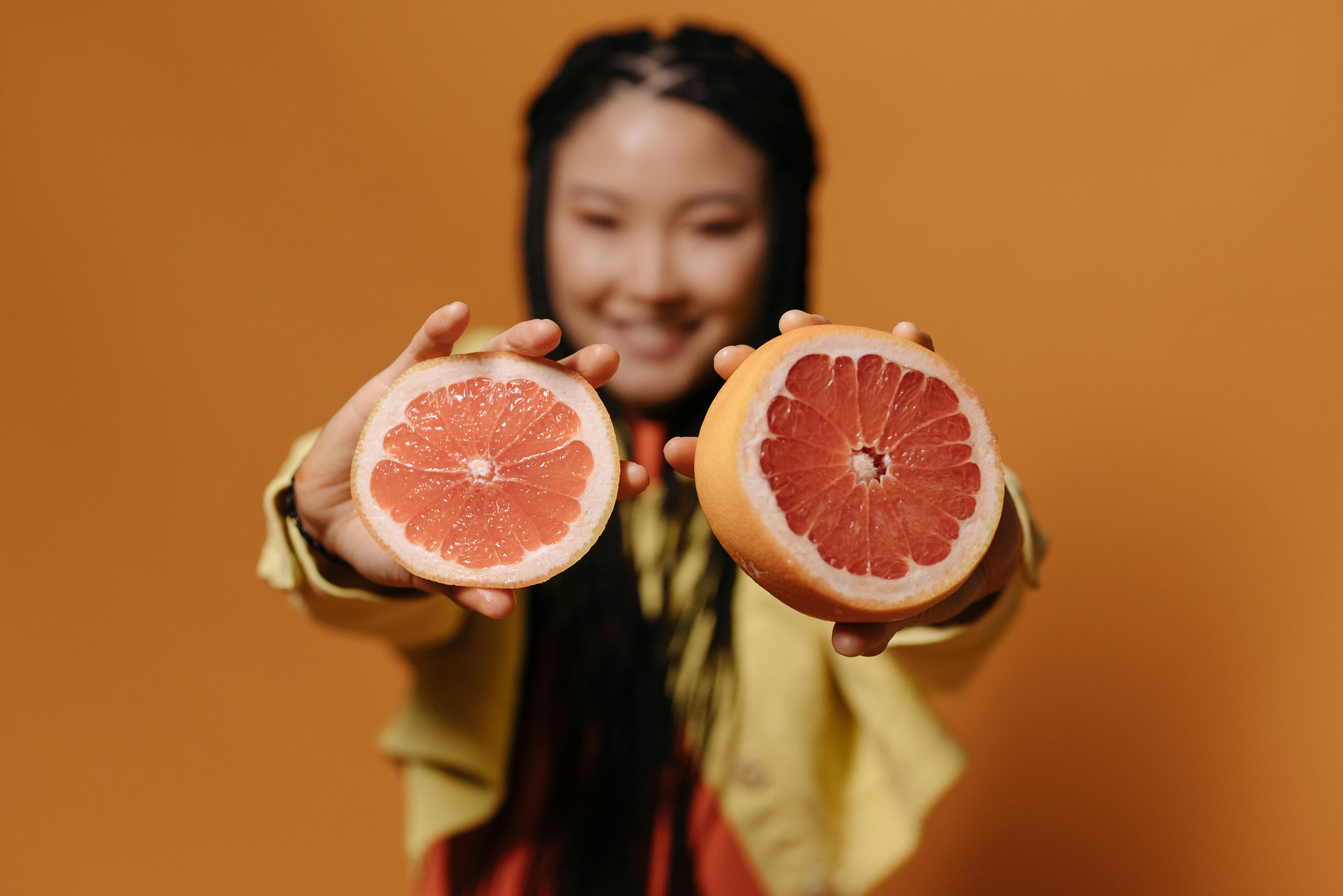 Woman Holding Sliced Grapefruit · Free Stock Photo