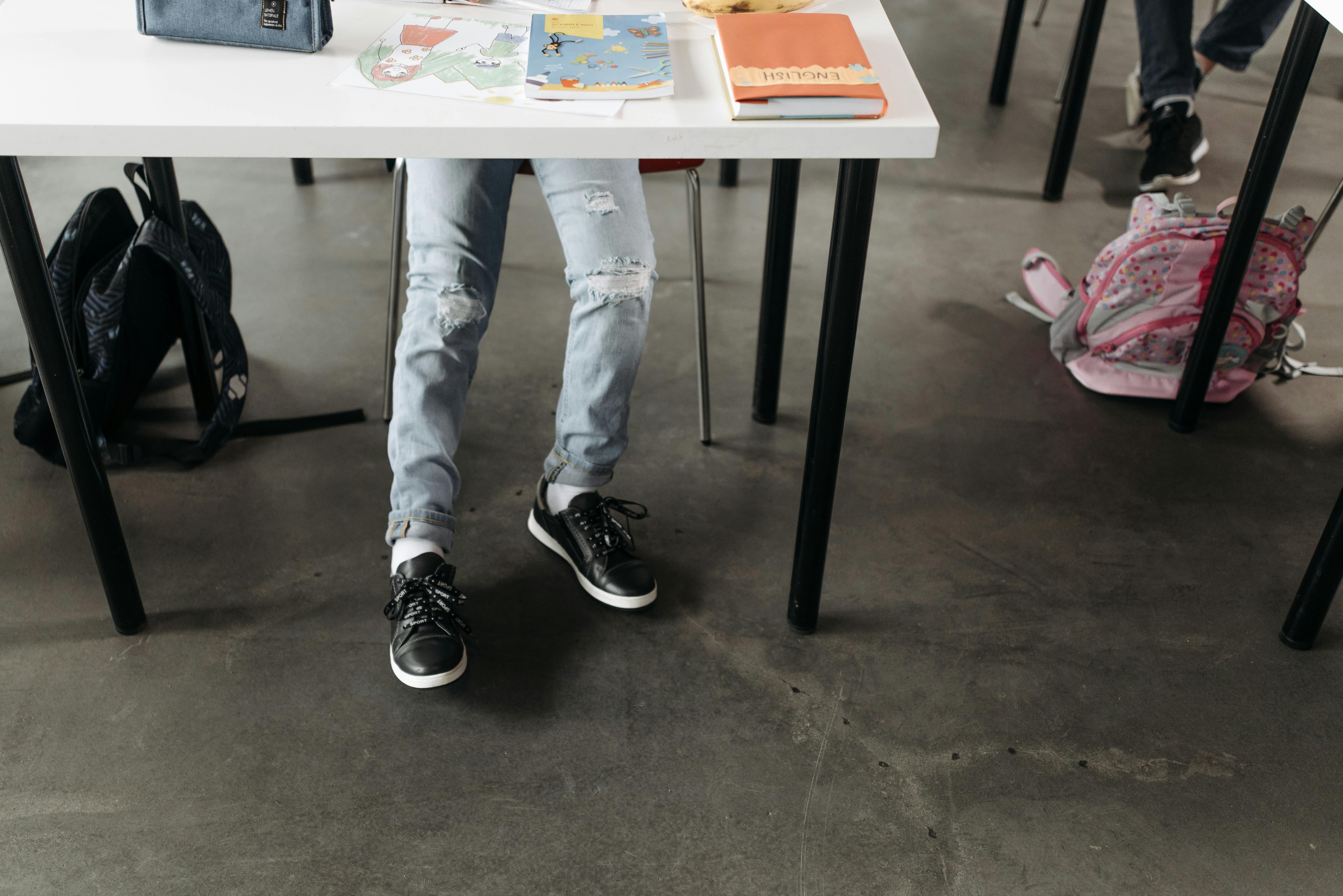 A Student Wearing Ripped Jeans and Black Sneakers in School · Free ...