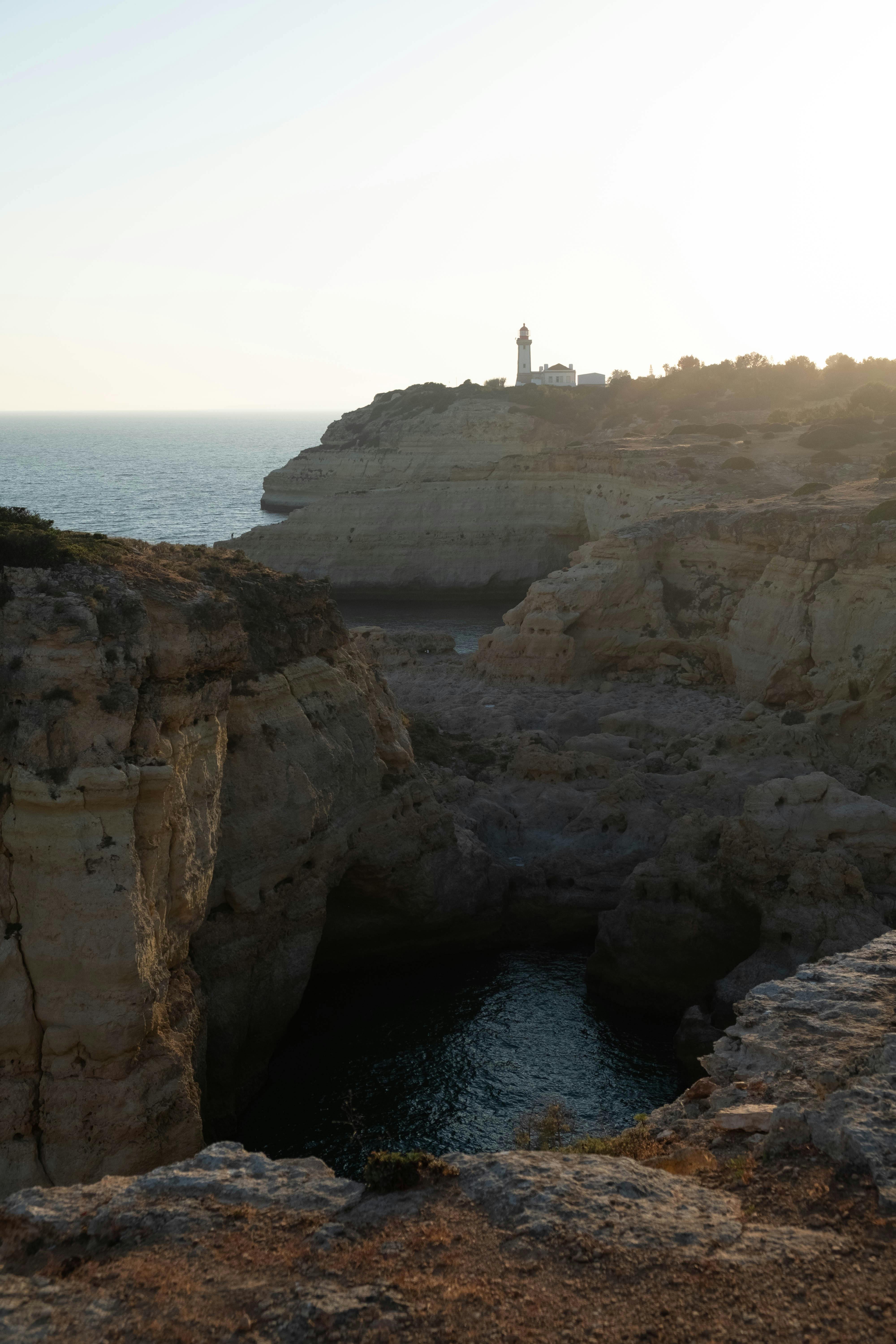 White Lighthouse on Cliff Beside Sea · Free Stock Photo