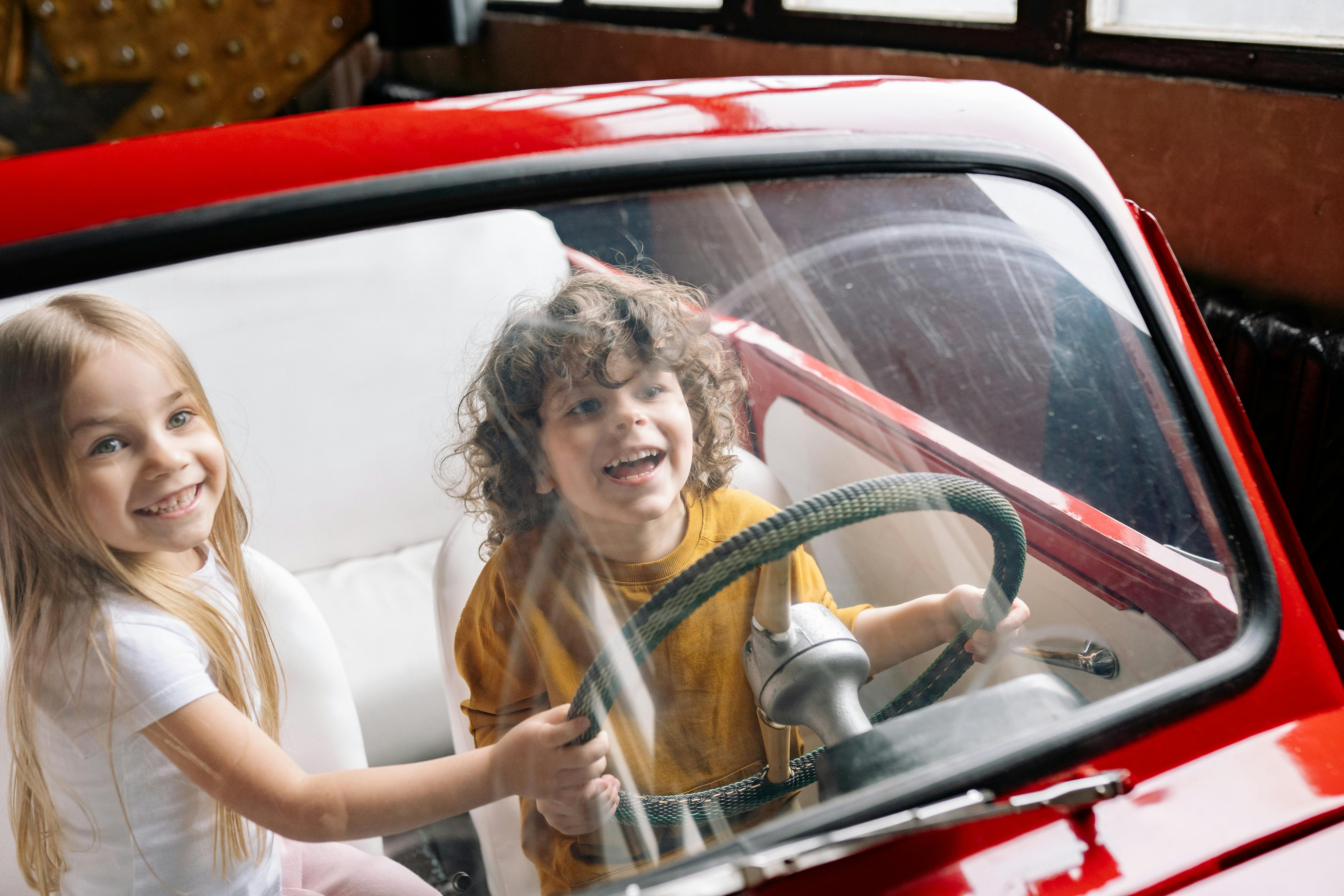 Kids Smiling in Car in Photo Studio · Free Stock Photo