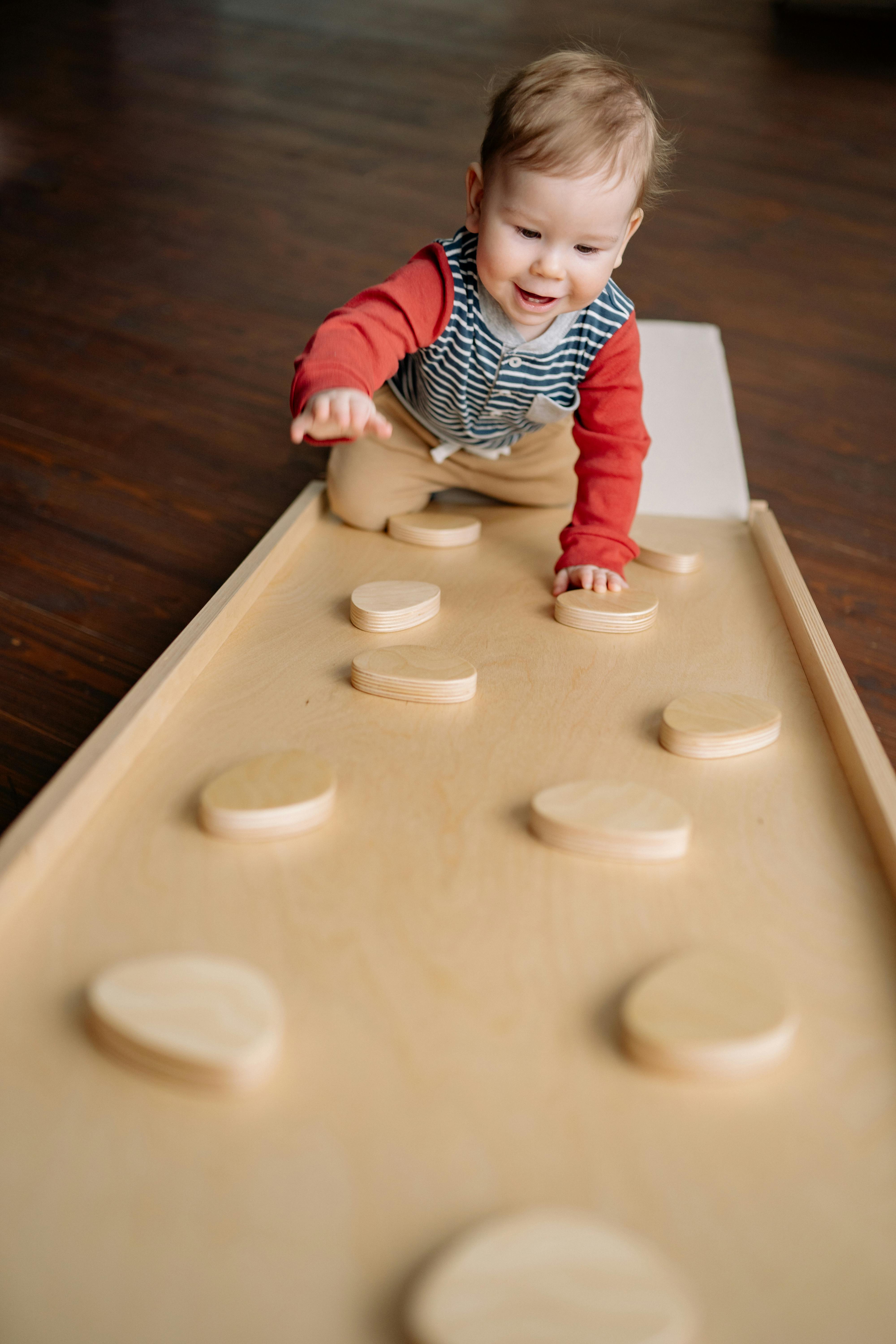 Baby Climbing Up a Little Wooden Climbing Wall · Free Stock Photo