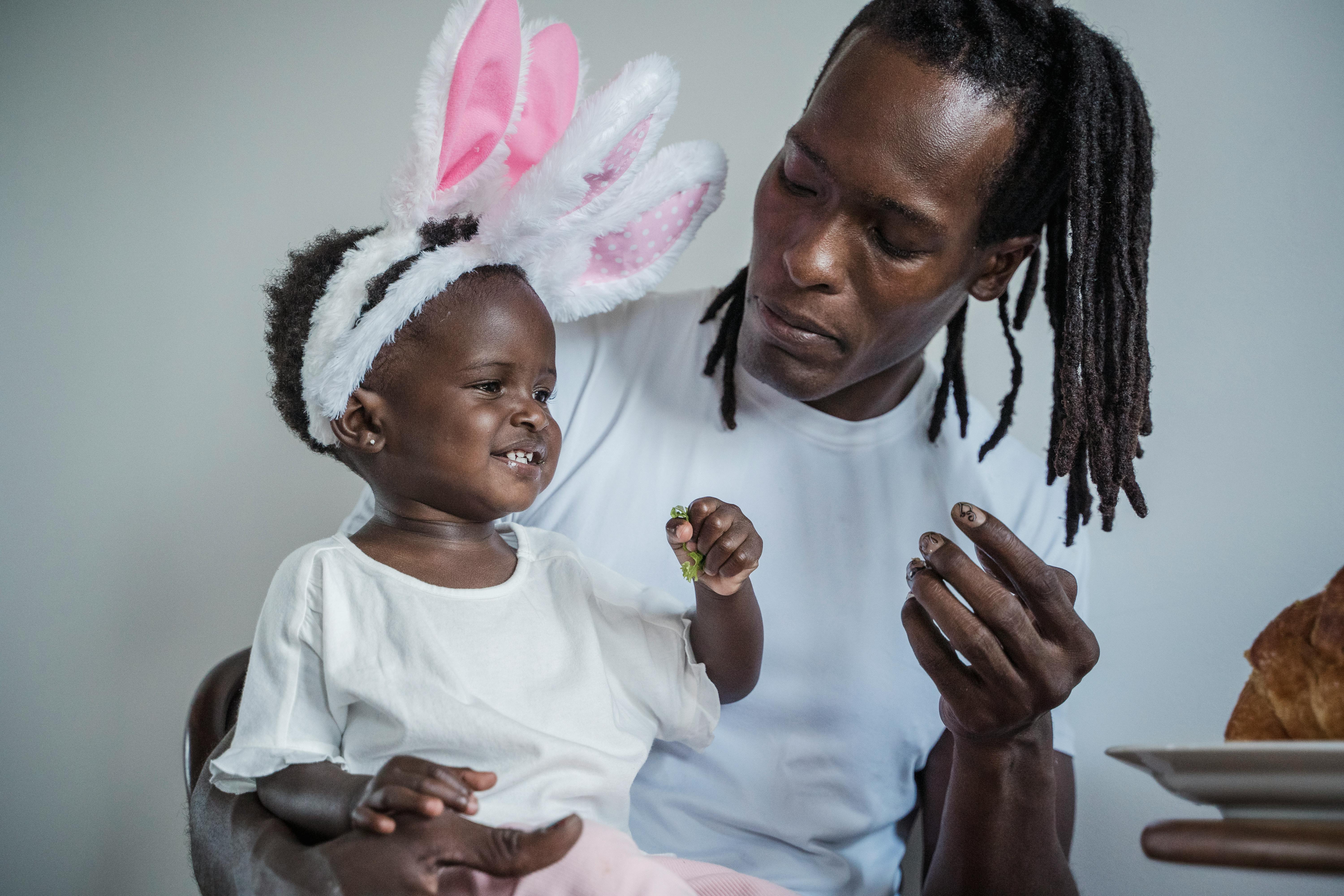 Portrait of Man Feeding his Baby Daughter with Rabbit Ears · Free Stock ...
