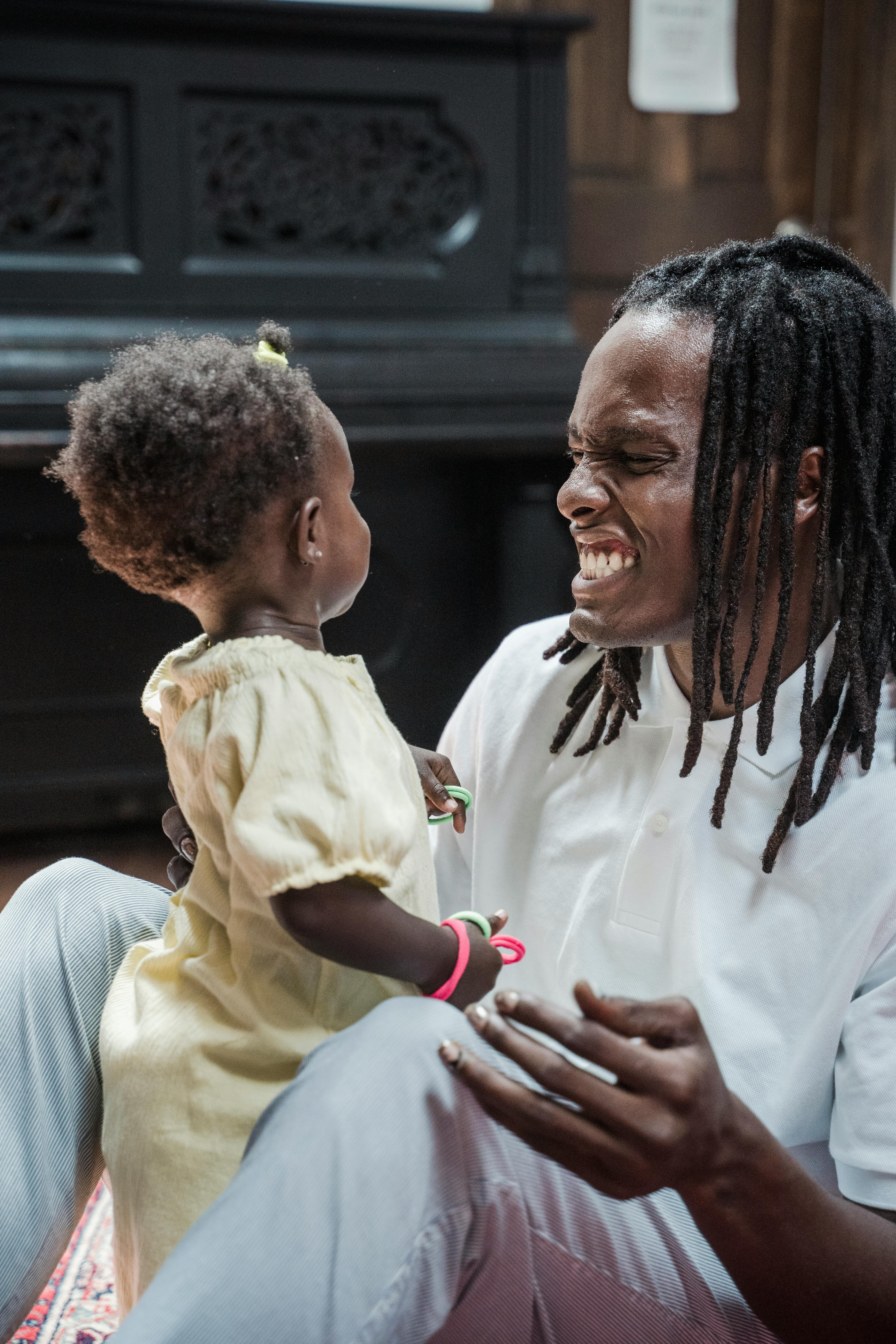 Father Making Faces and Playing with his Baby Daughter · Free Stock Photo