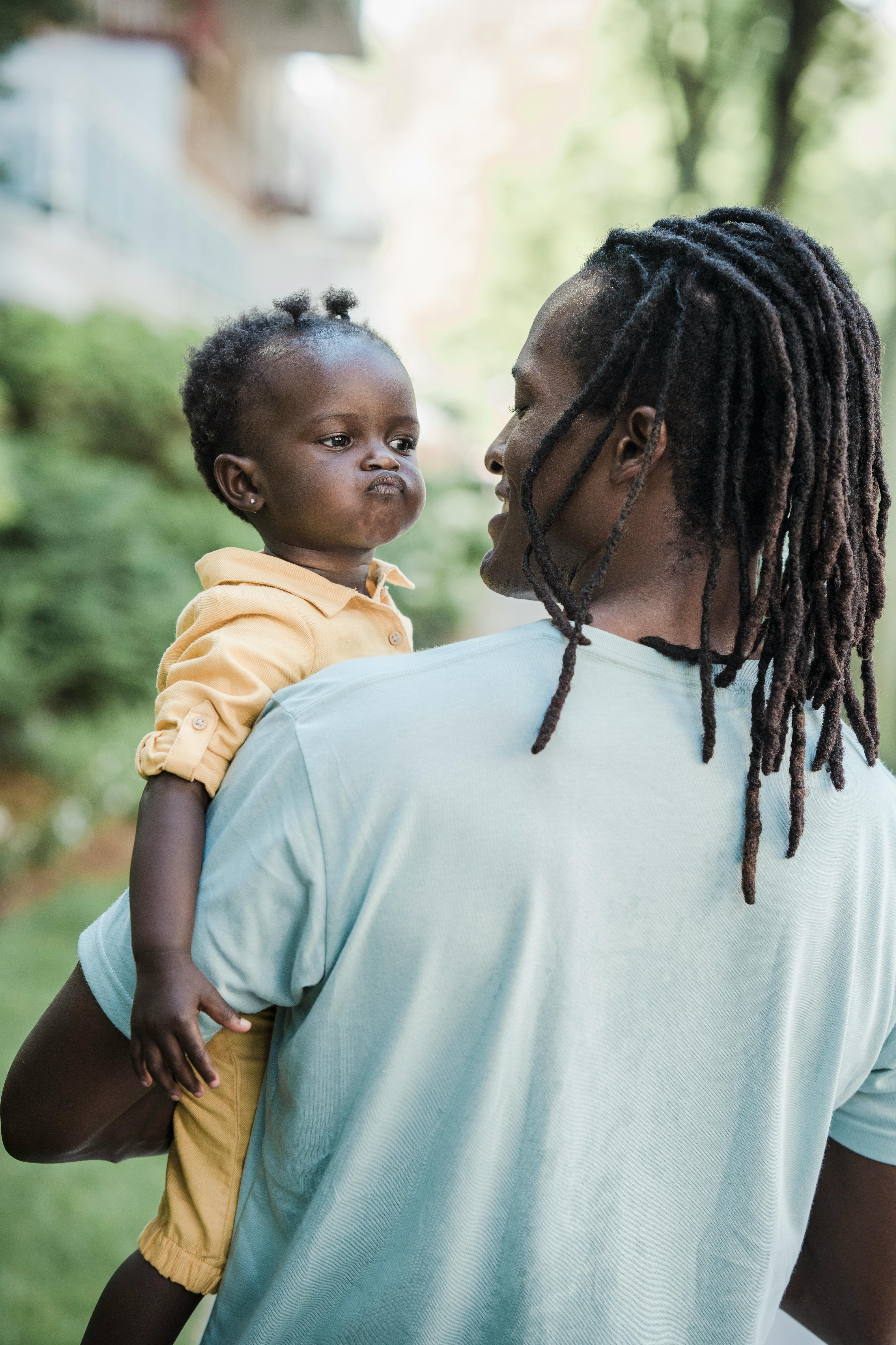 A Man Carrying a Child · Free Stock Photo