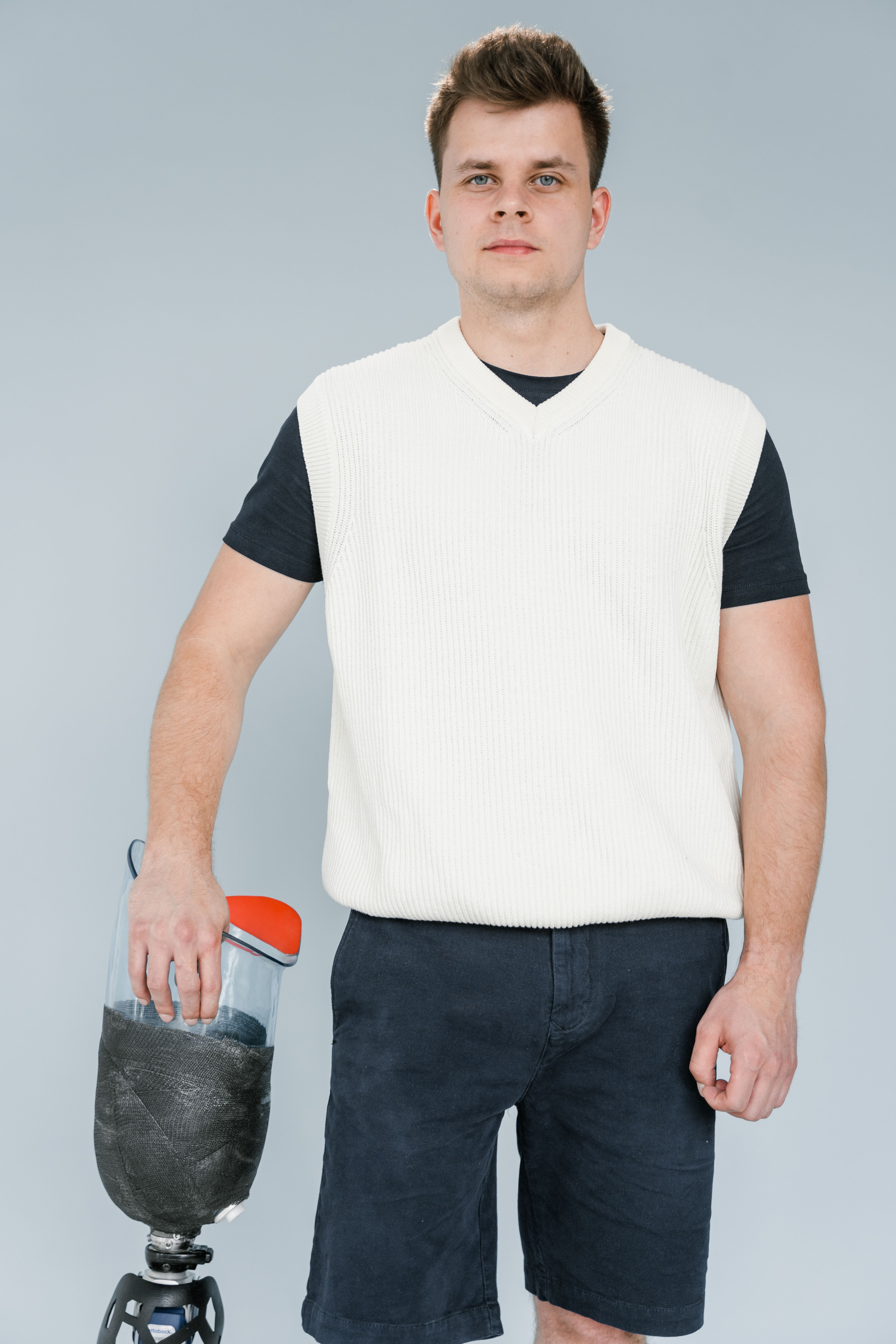 A Man Wearing a Sweater Vest Holding a His Prosthetic Leg · Free Stock ...