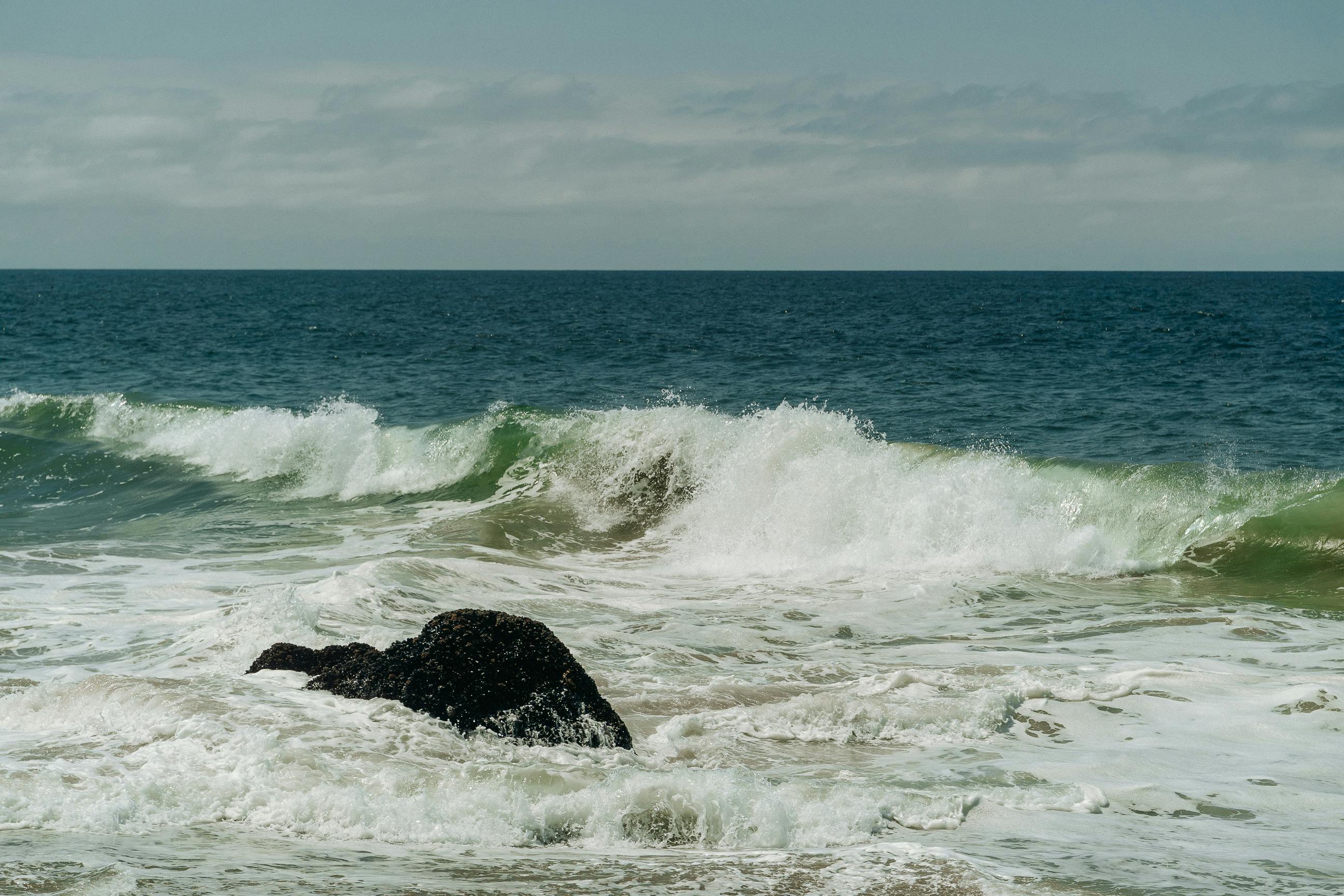 Black Rock Formation near Ocean Waves · Free Stock Photo
