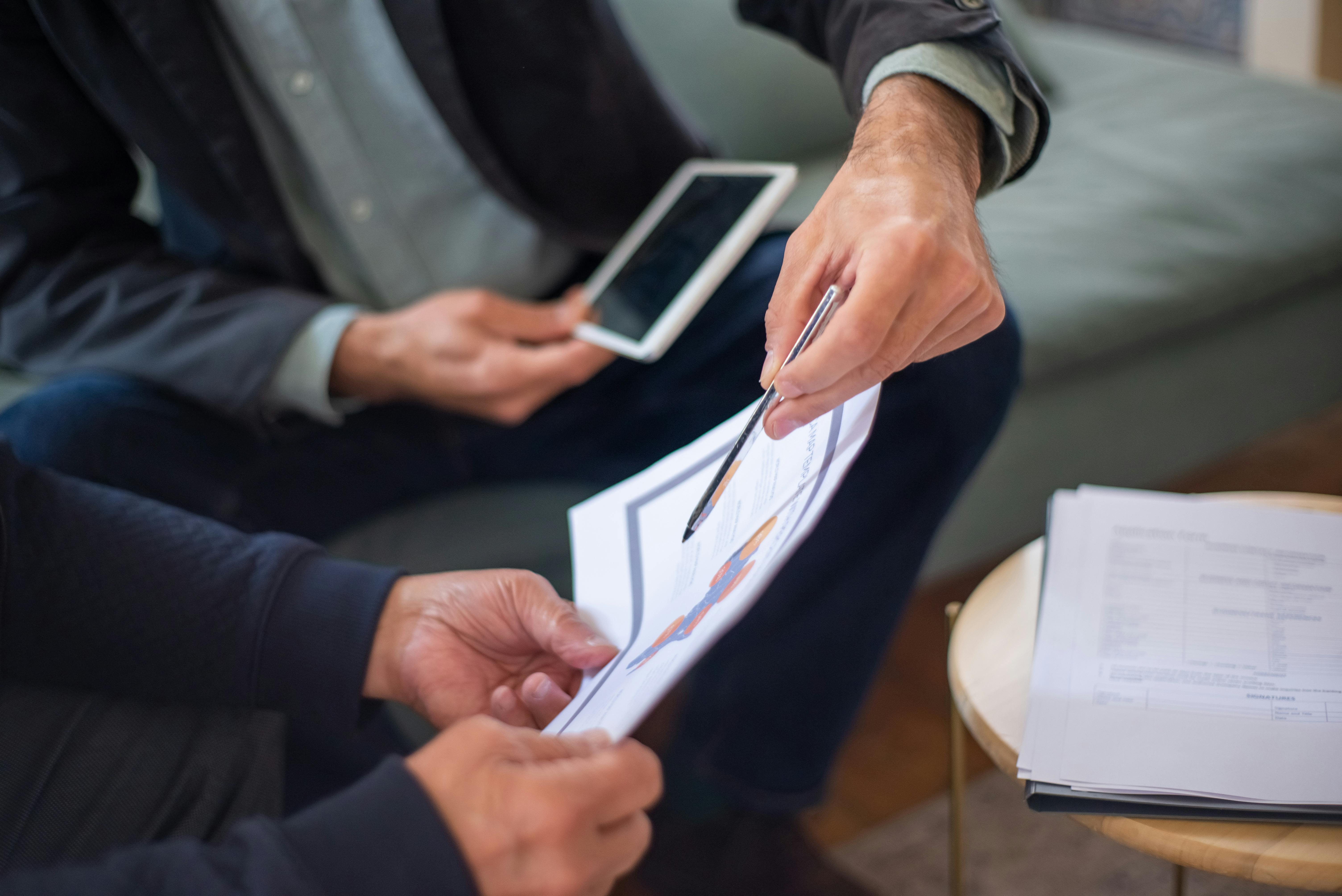 A Couple Holding Hands on Top of Documents · Free Stock Photo