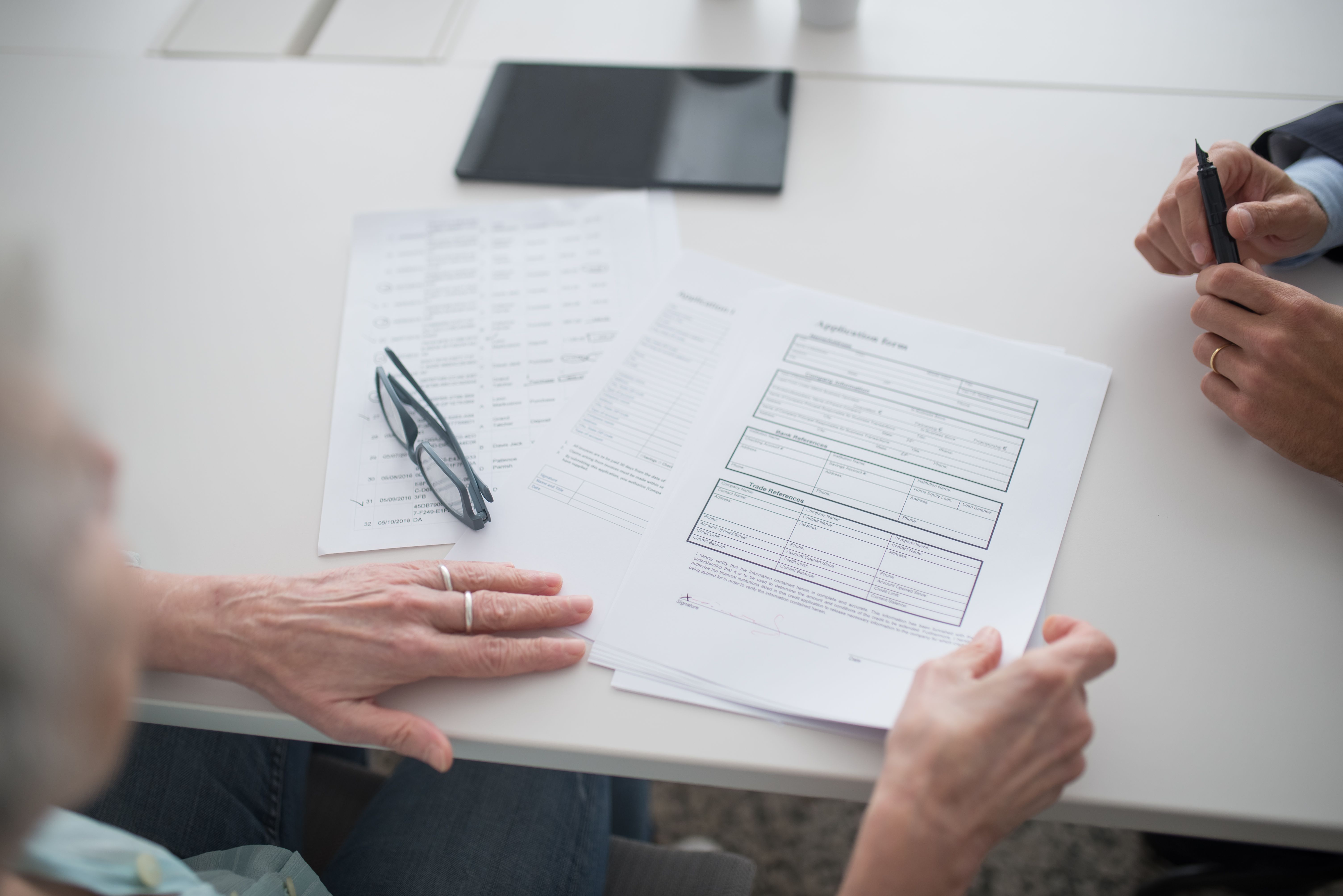 A Person Holding the Documents on the Table · Free Stock Photo