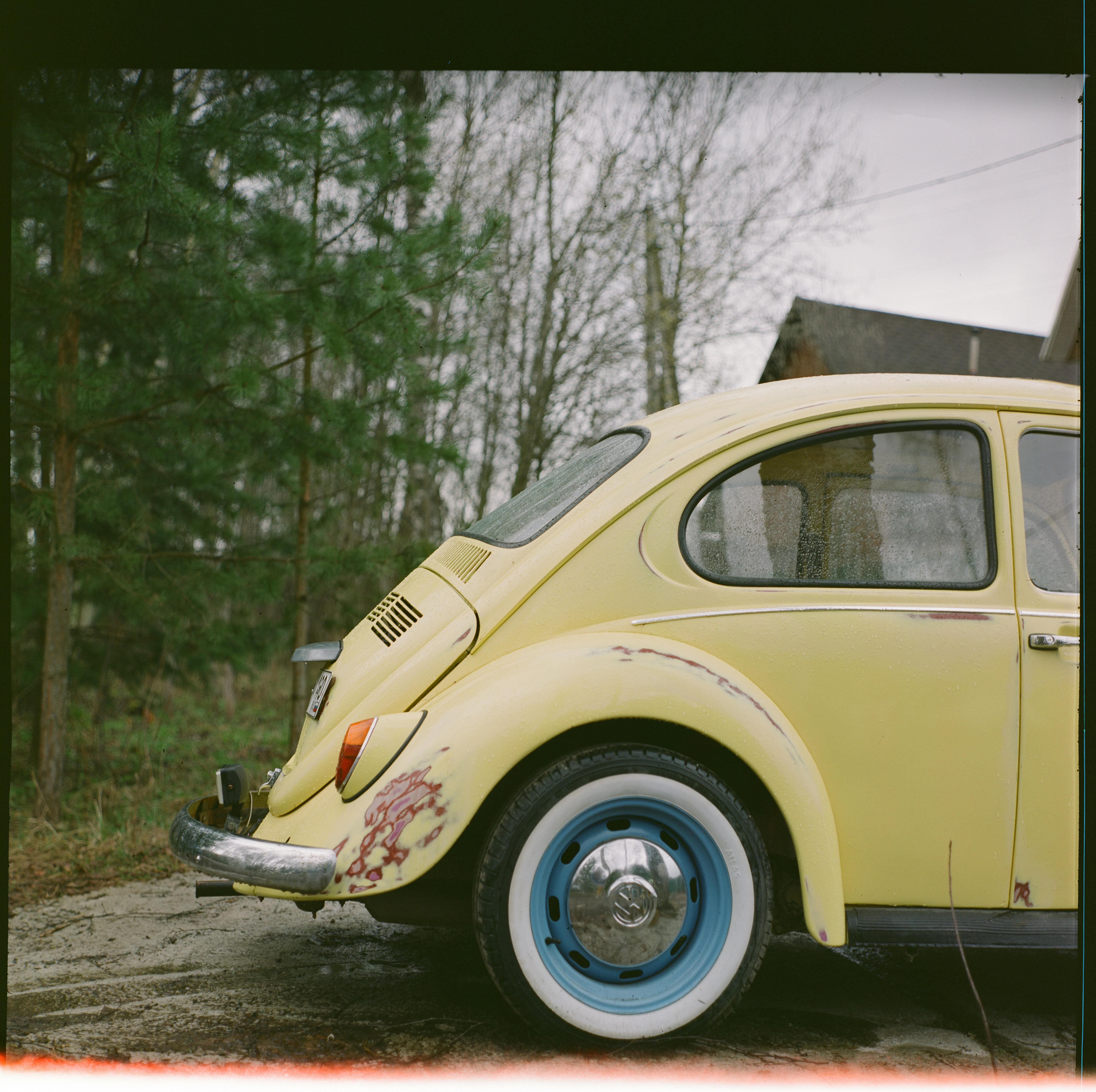 A Yellow Classic Beetle Car Parked on Dirt Road · Free Stock Photo