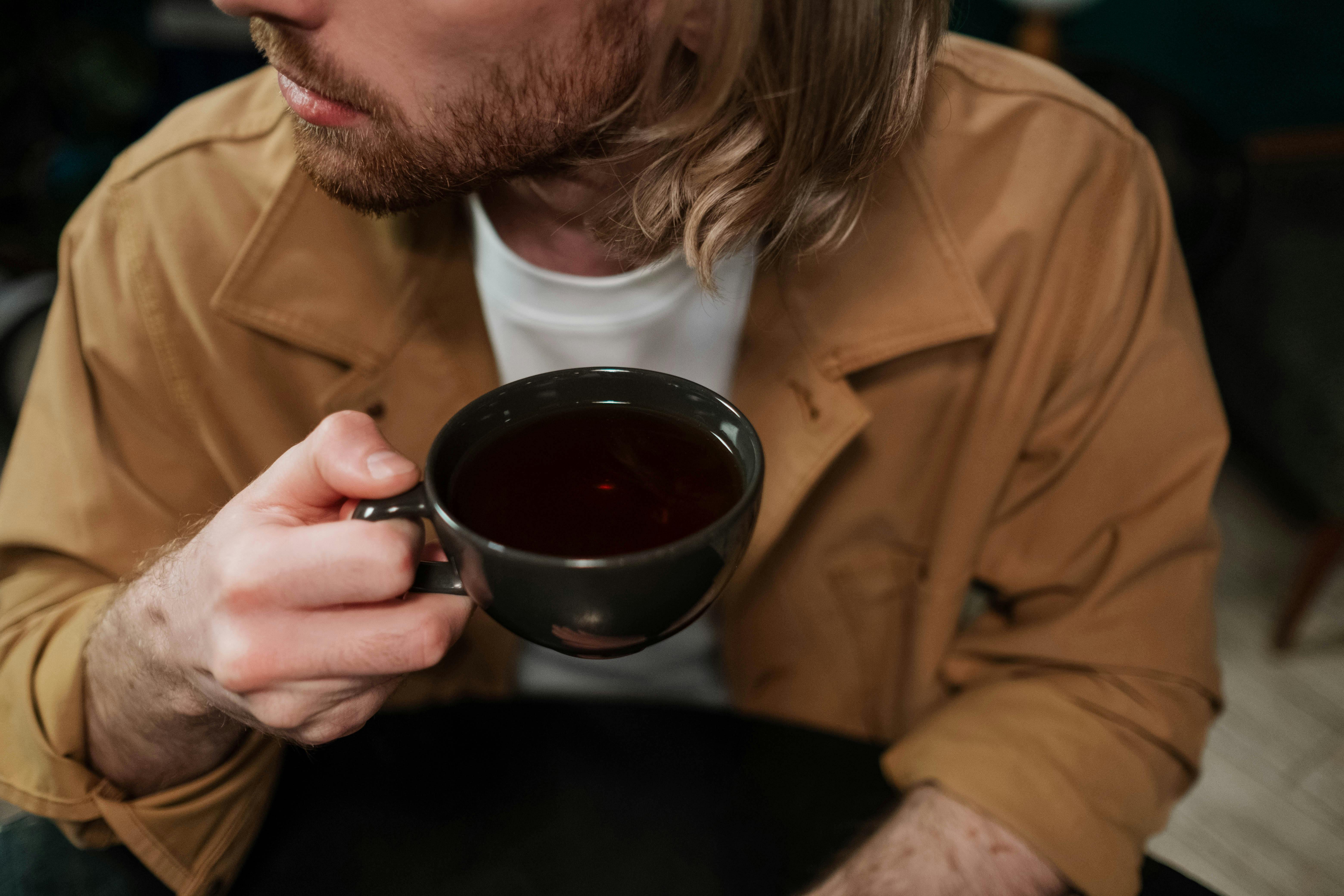Man in Brown Jacket Holding Black Ceramic Mug · Free Stock Photo