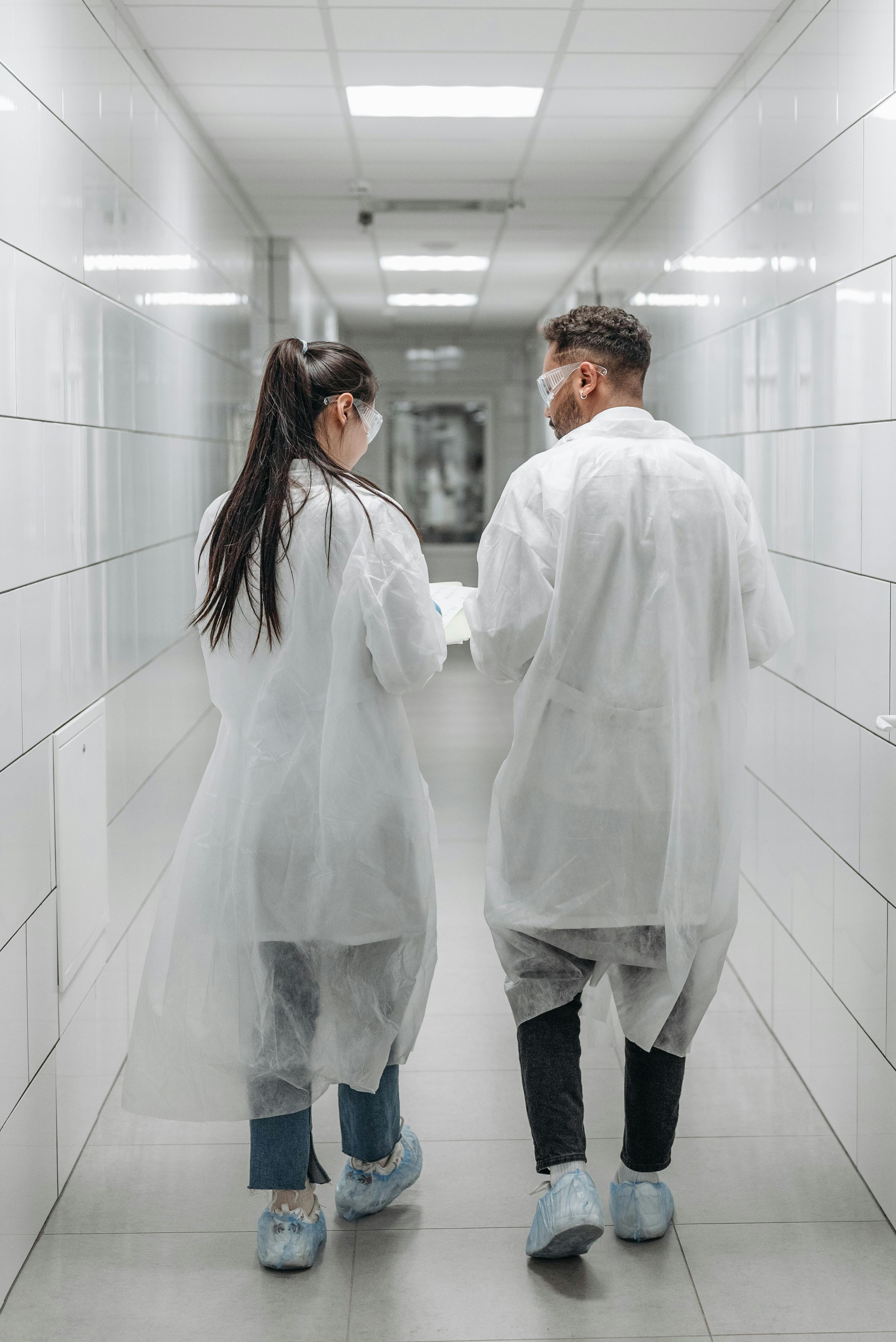 A Man and a Woman Walking in a Hallway · Free Stock Photo