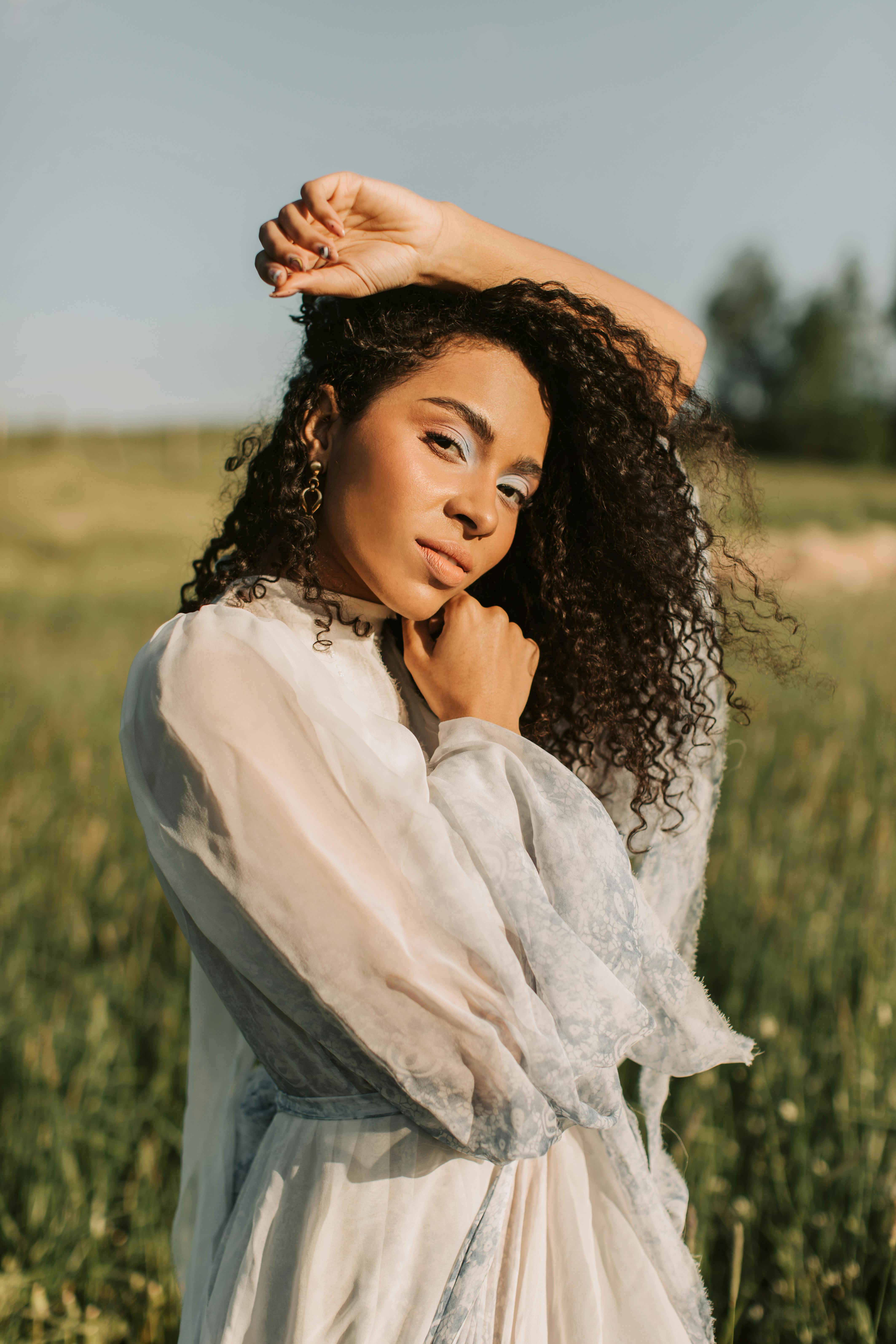 Photo of Woman in White Dress Posing with Her Head up and Her Hands ...