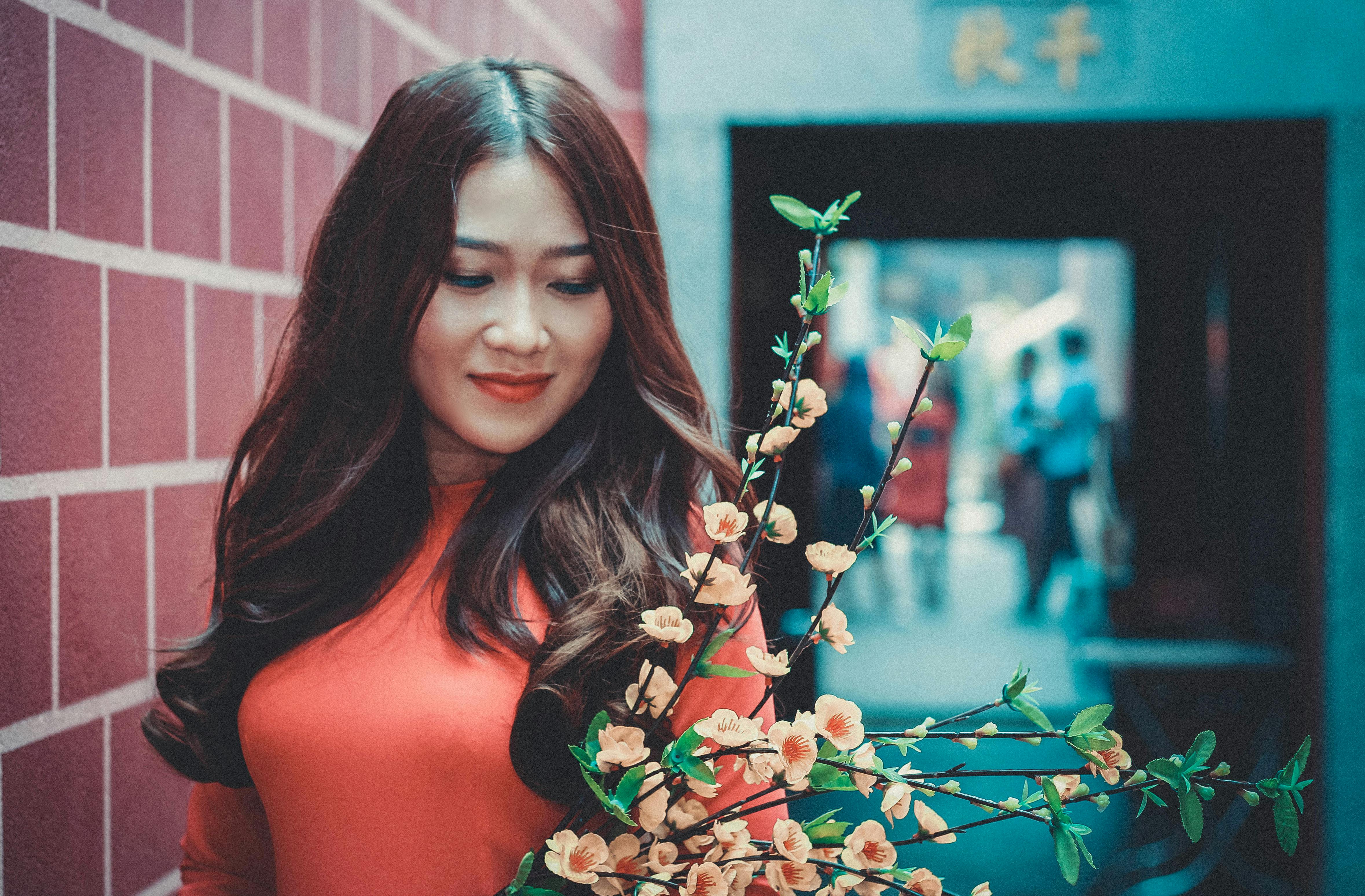 Woman Wearing Red Long-sleeved Shirt in Front of Flower · Free Stock Photo