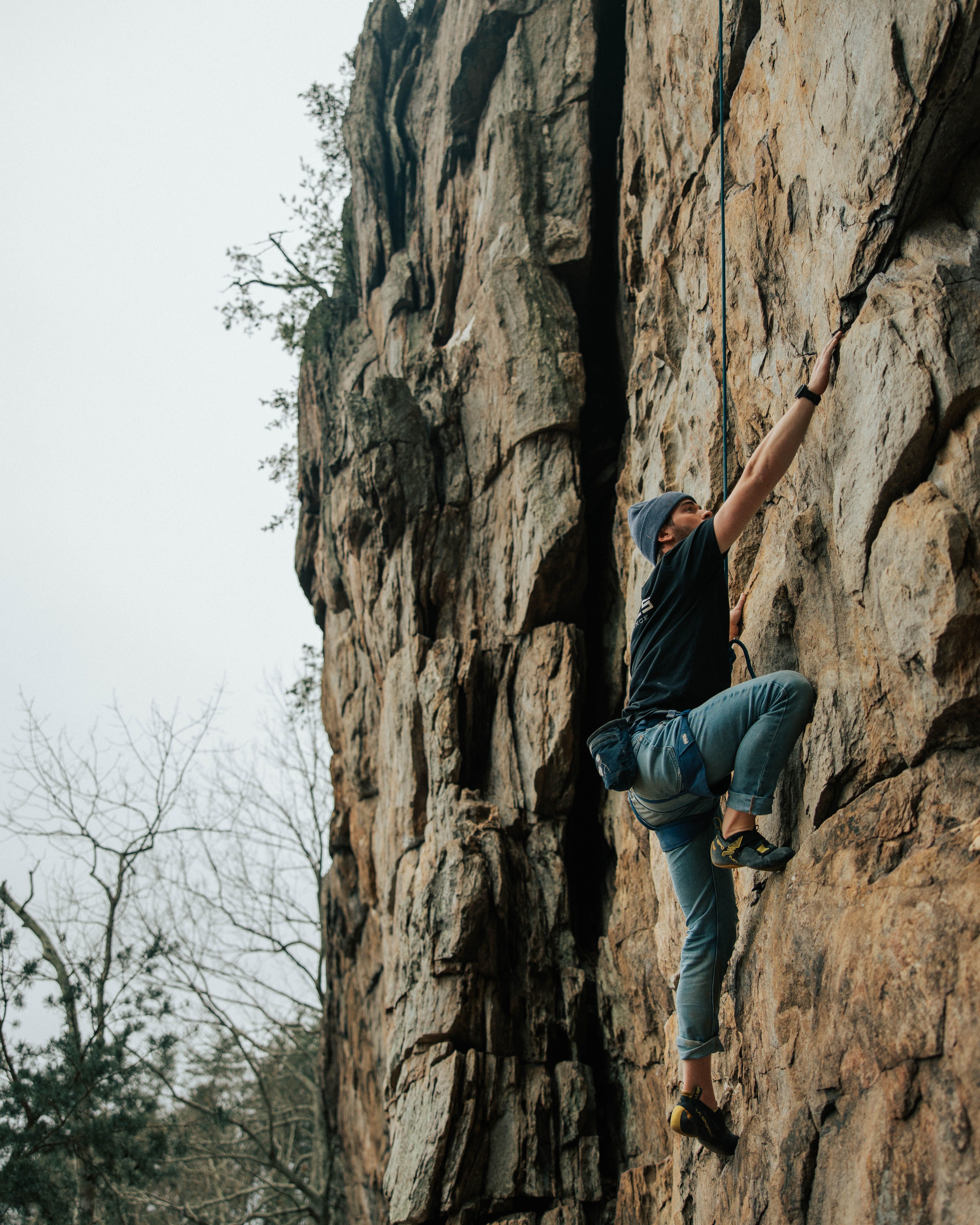 Man in Blue Jeans Climbing on Rocks · Free Stock Photo